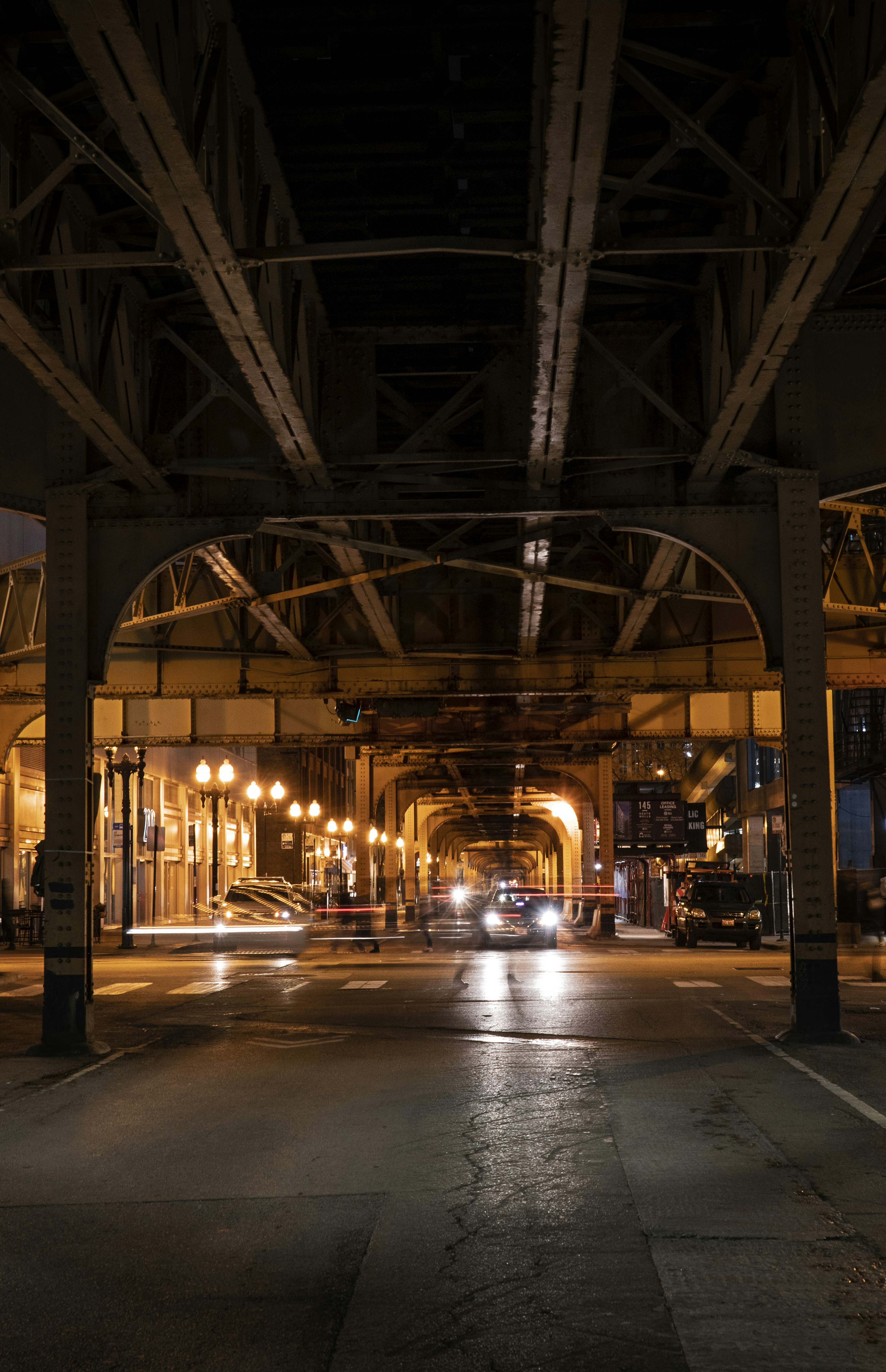 Midnight Beneath the Iron Arches: A City Street in Motion