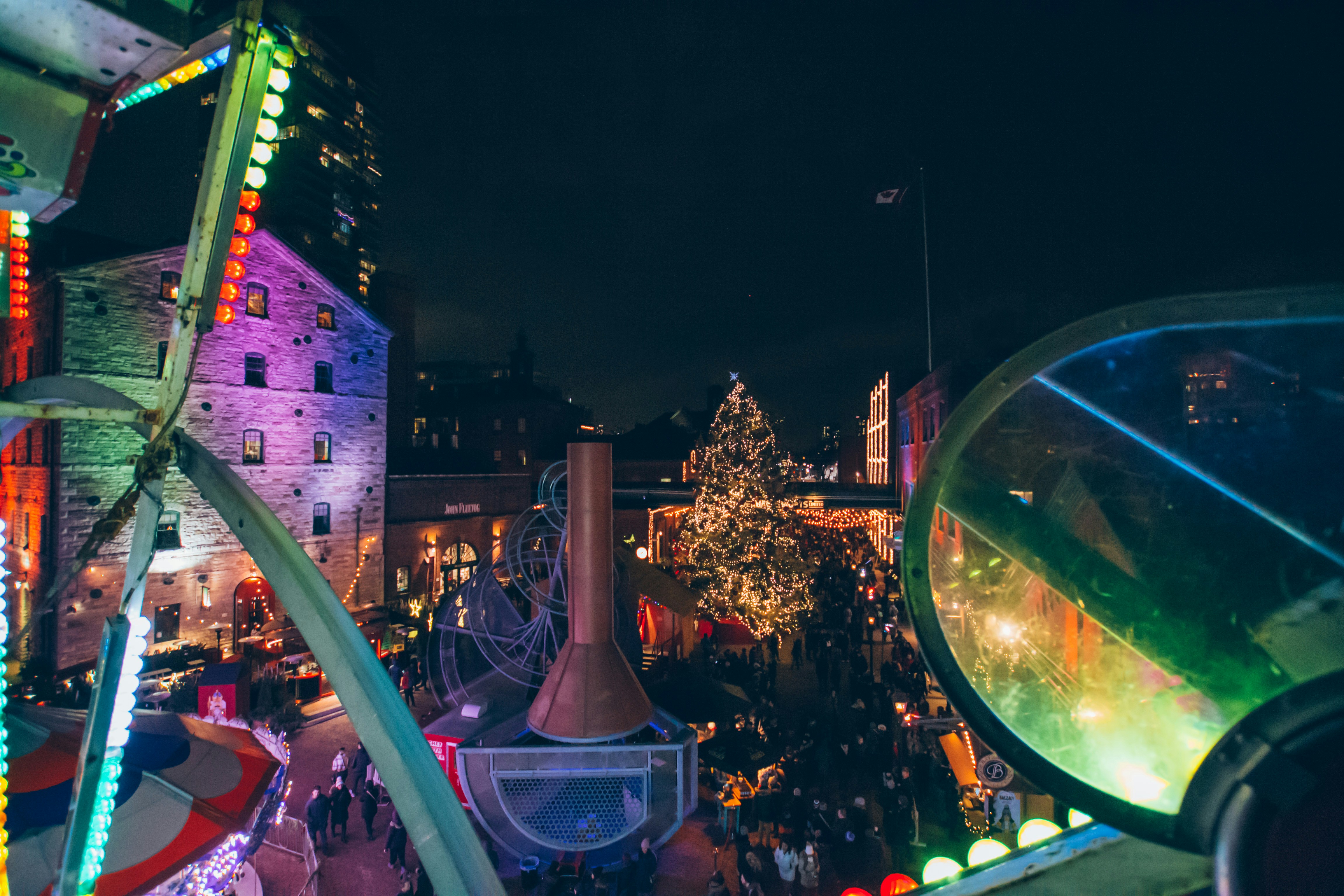 Night Carnival in Neon Lights: A Panorama of Colorful Rides and a Festive Tree