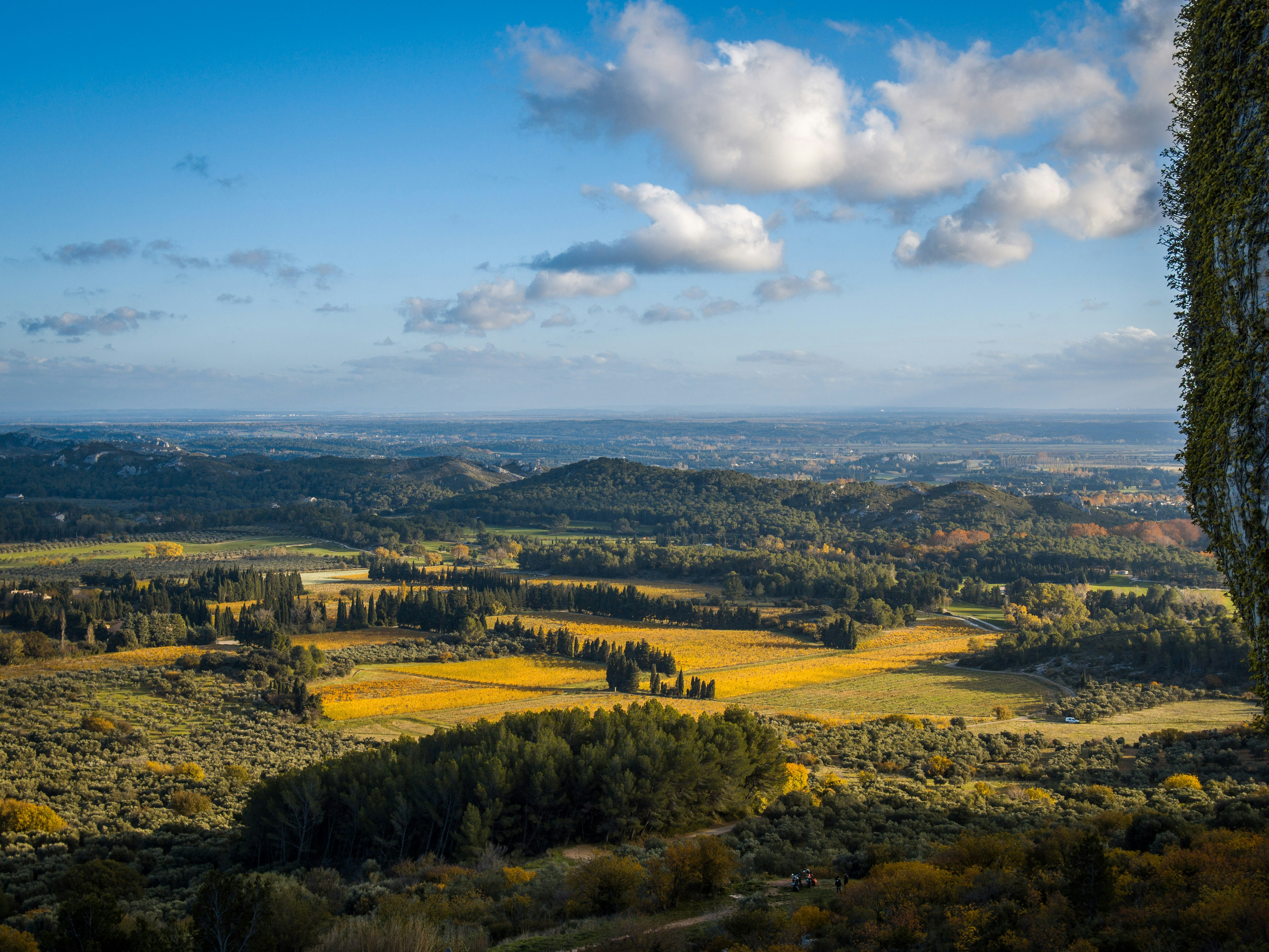 Vast landscape showcasing vibrant autumn foliage with rolling hills and a clear blue sky. The scene captures the tranquility of nature's seasonal transition.