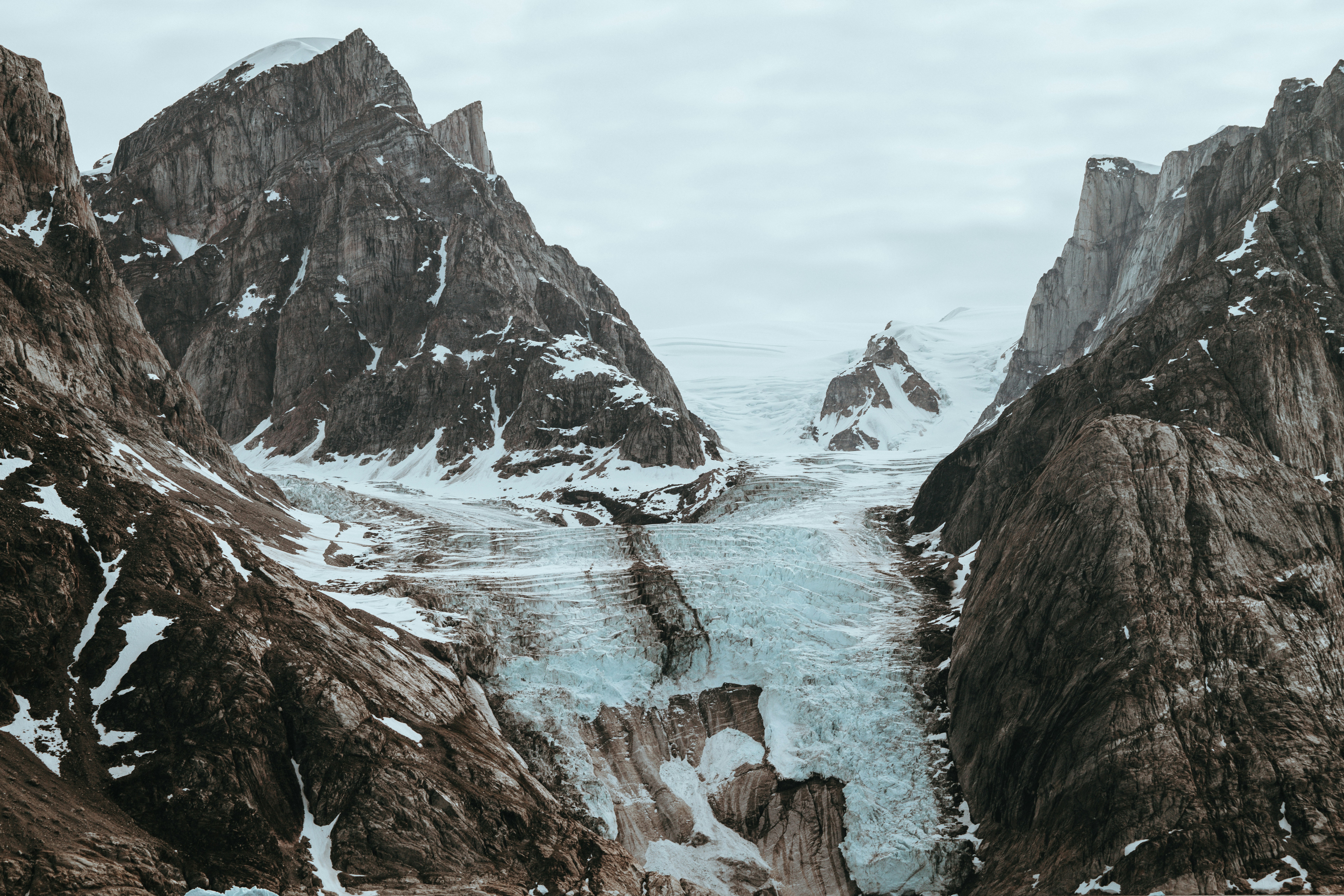 Ice Ribbon in a Narrow Alpine Gorge Between Dark Granite Spires