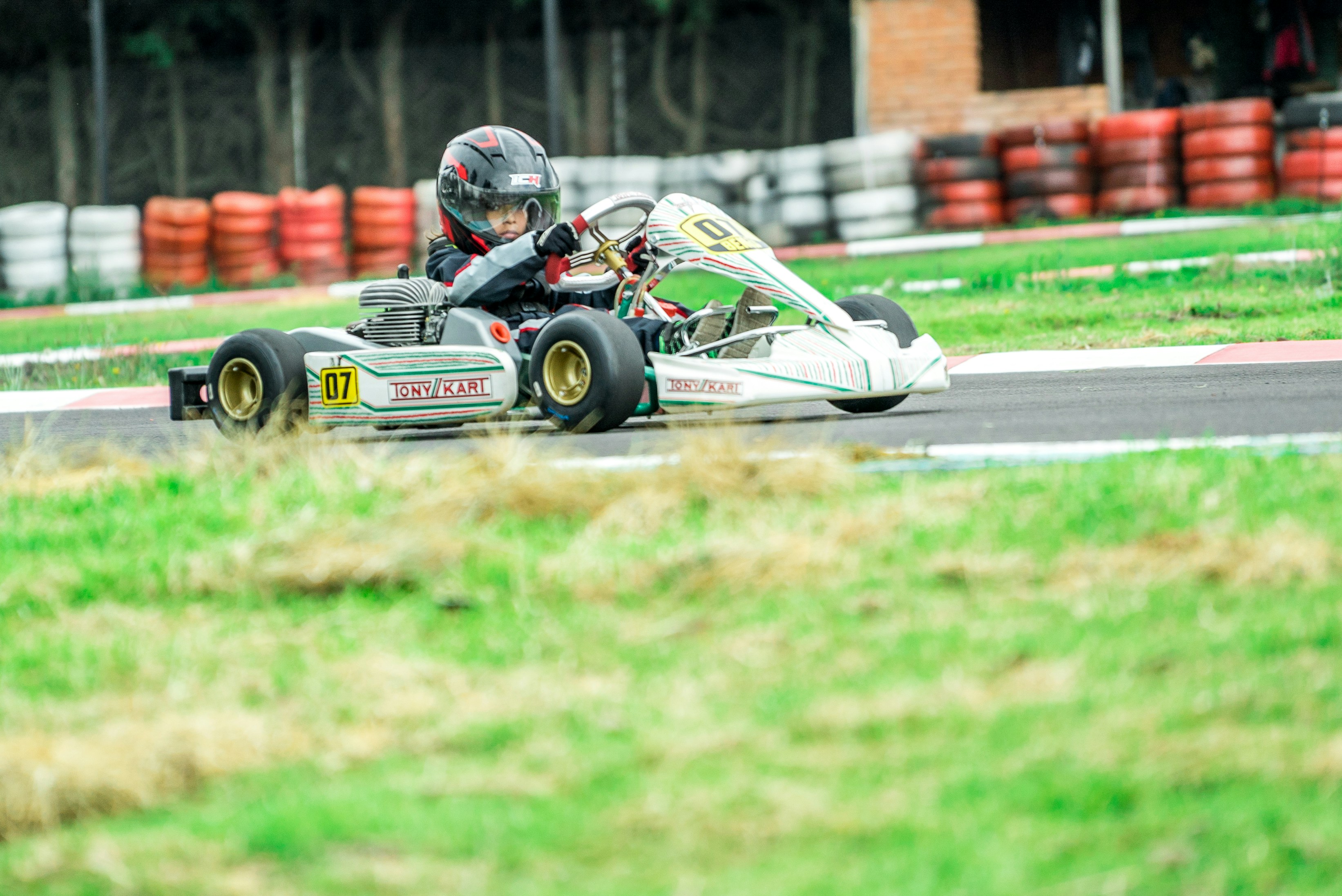 Racing kart in mid‑turn: a sprint through the green and red barriers