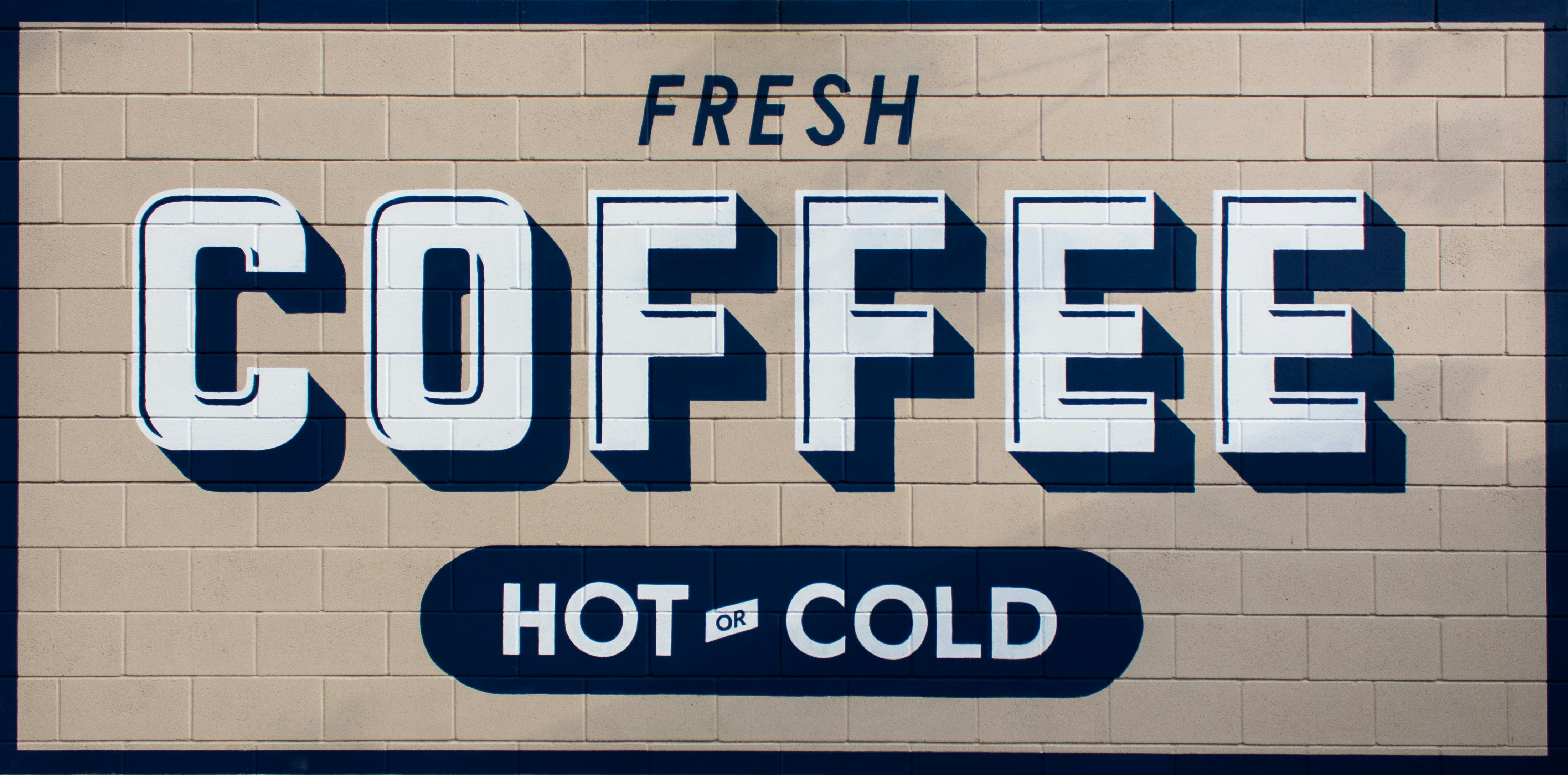 A sign outside of Blue copper Coffee in SLC, aspect adjusted to have a sign look even though it’s on a brick wall.