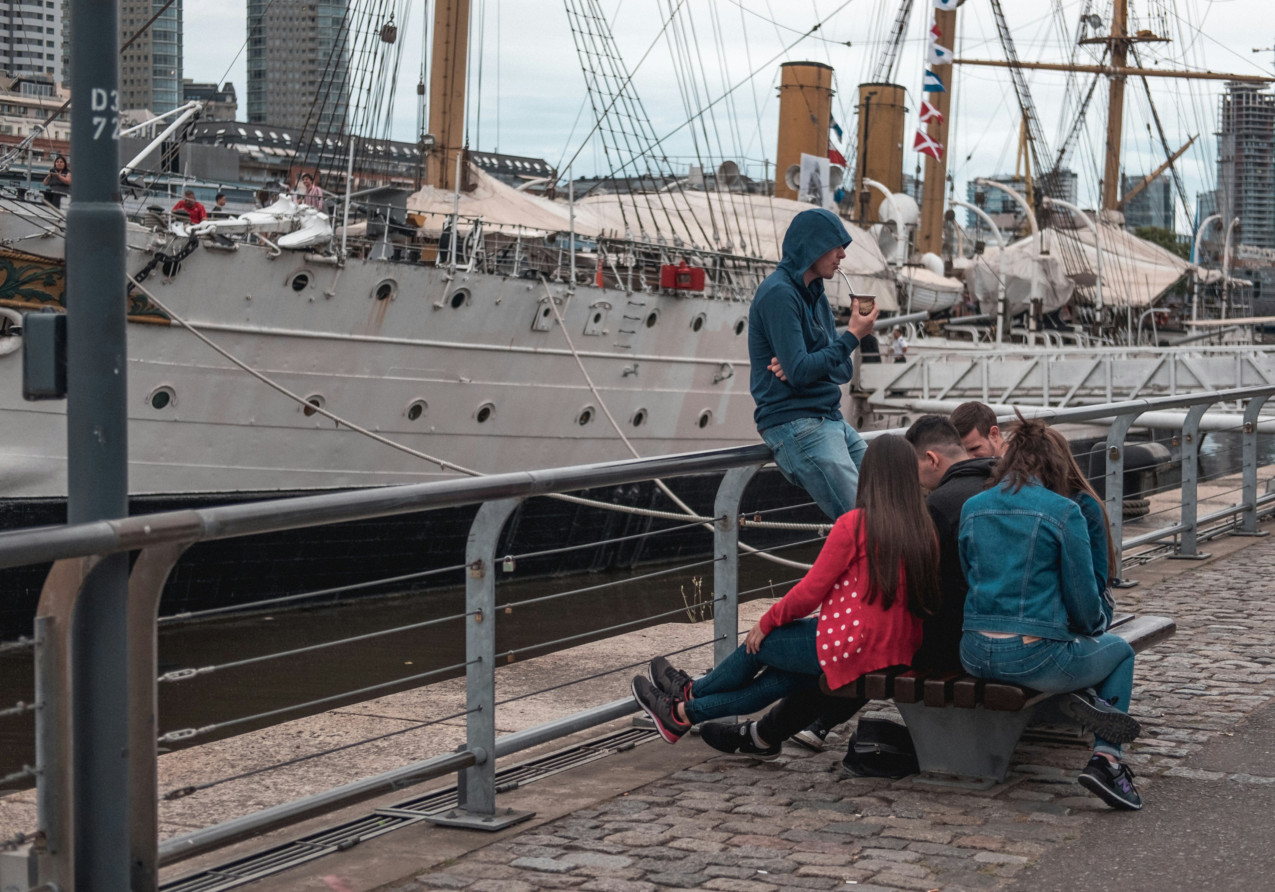 Quayside Pause Beneath Masts: Friends by a Historic Sailship