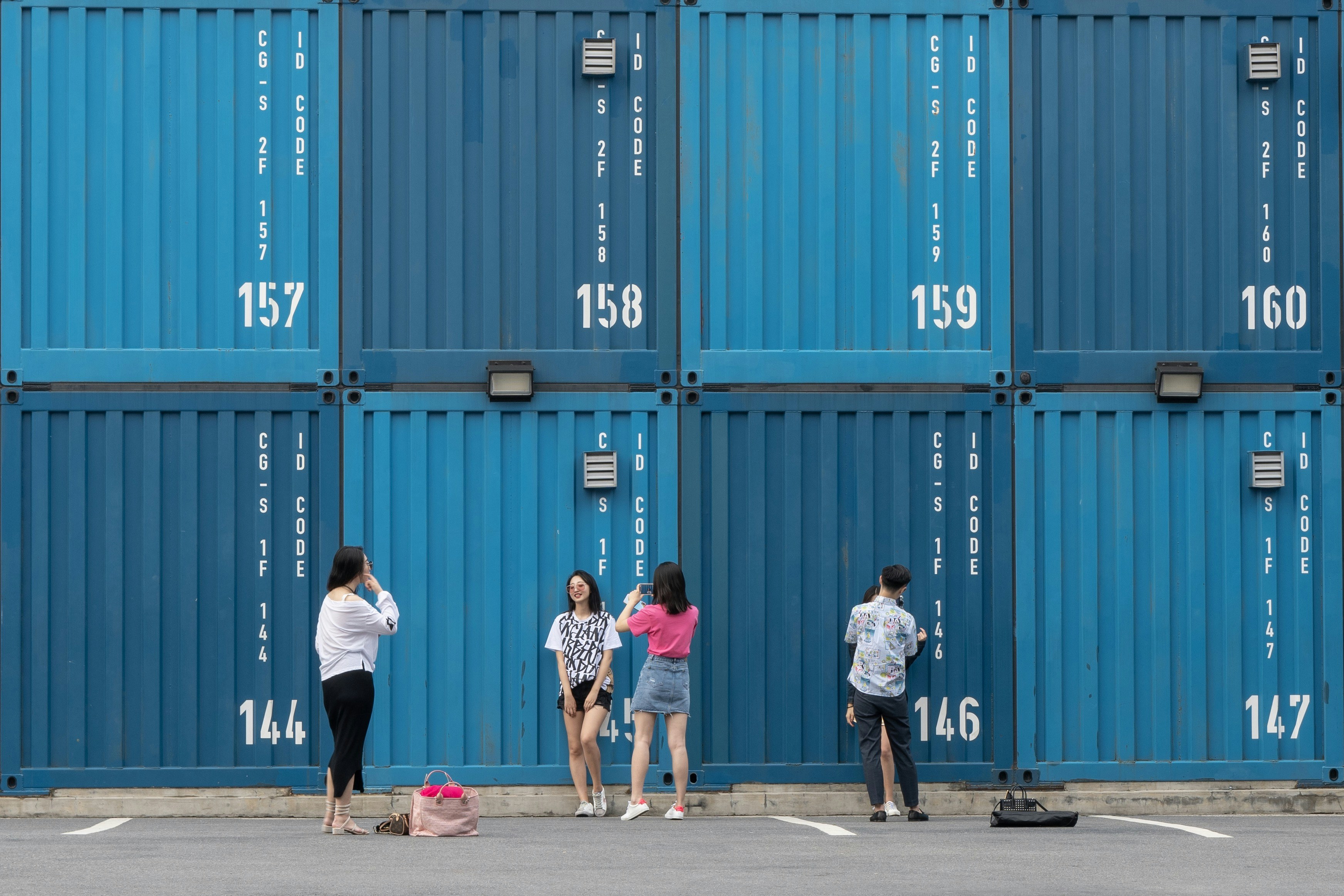 Five women and man standing near shipping containers during daytime ...