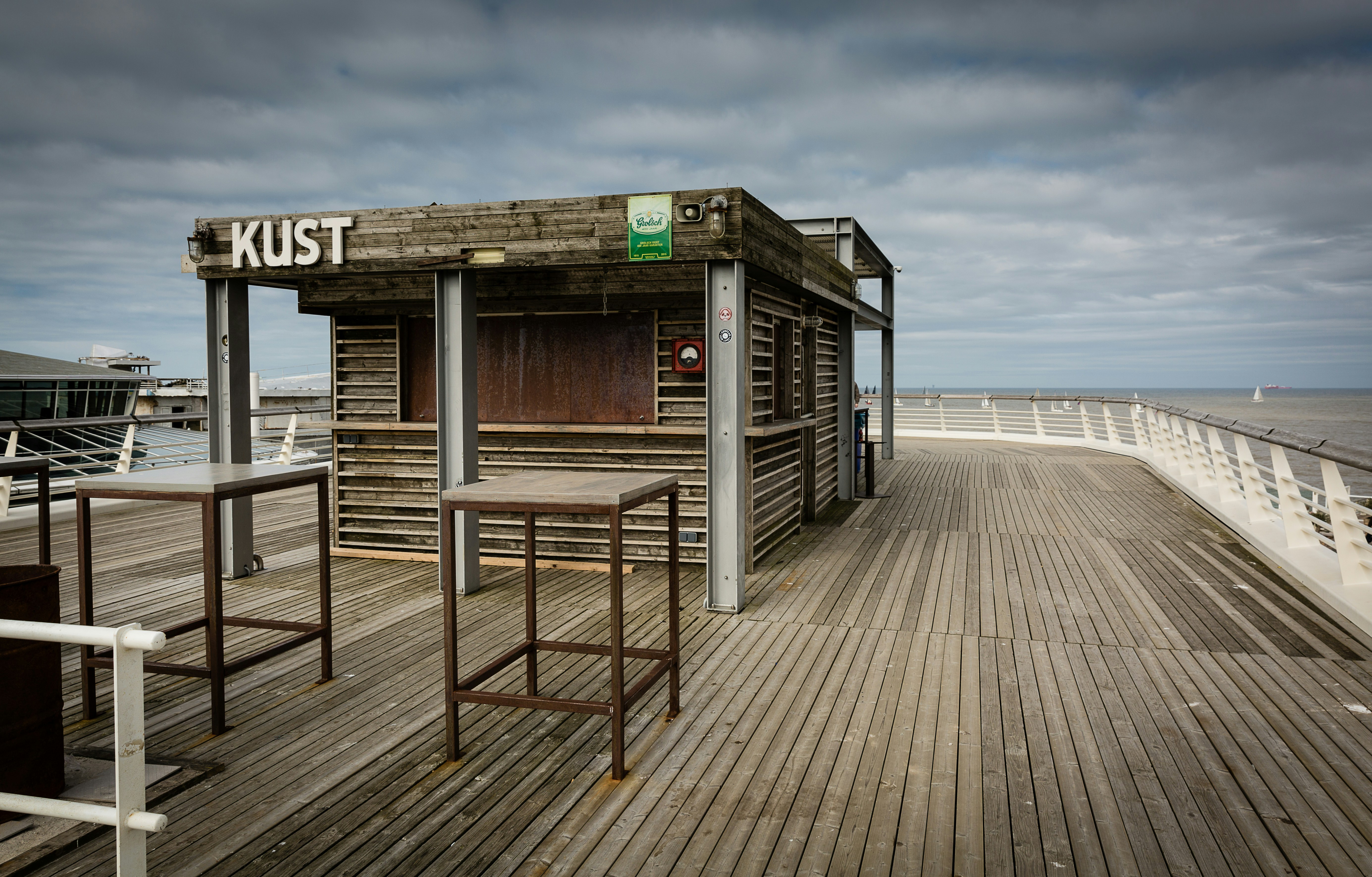 An abandoned snack shack at the end of the pier of Scheveningen. We had to go back for something to eat… | brown wooden tables