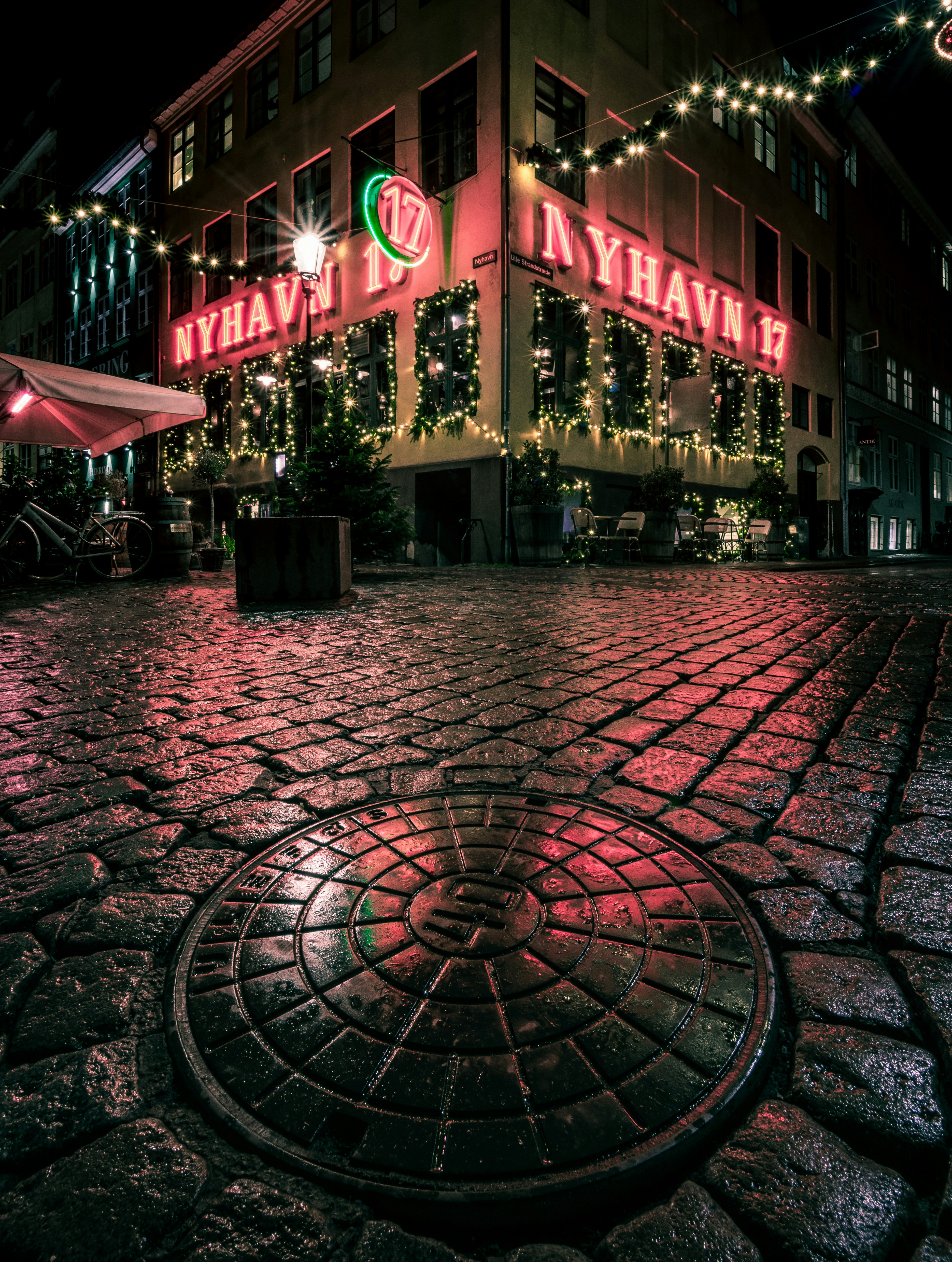Neon Cobblestones: a City Café Night under Festive Lights