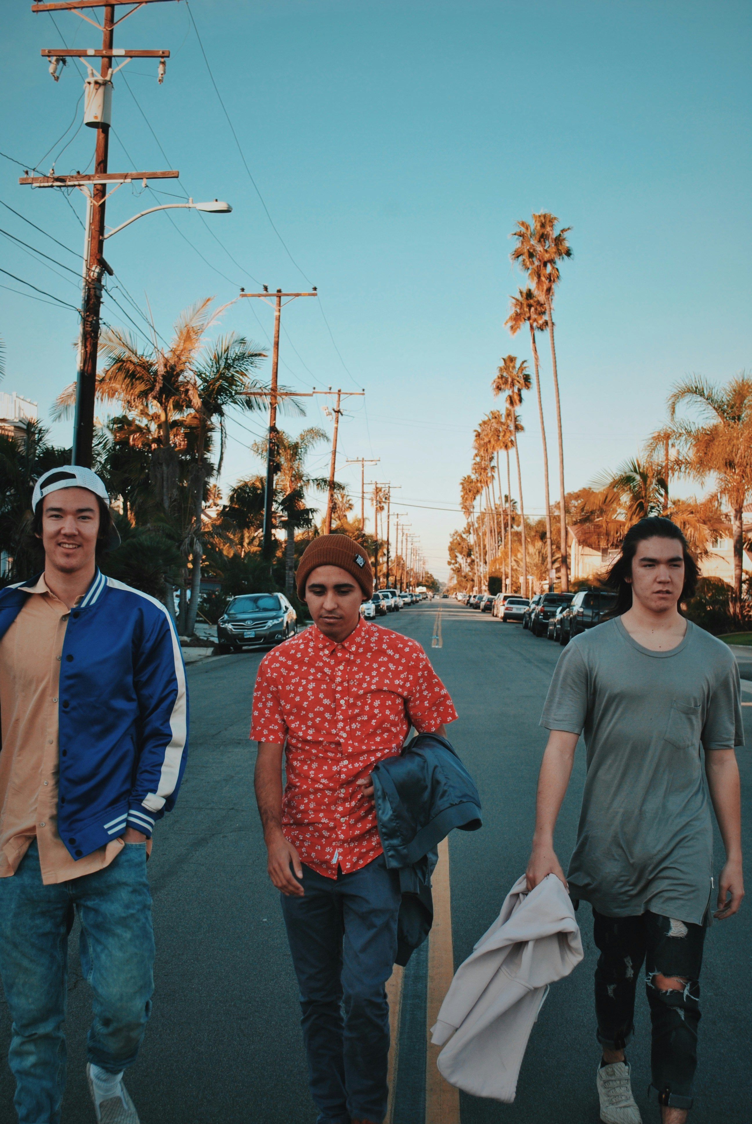 Three man walking on road photo – Free Person Image on Unsplash