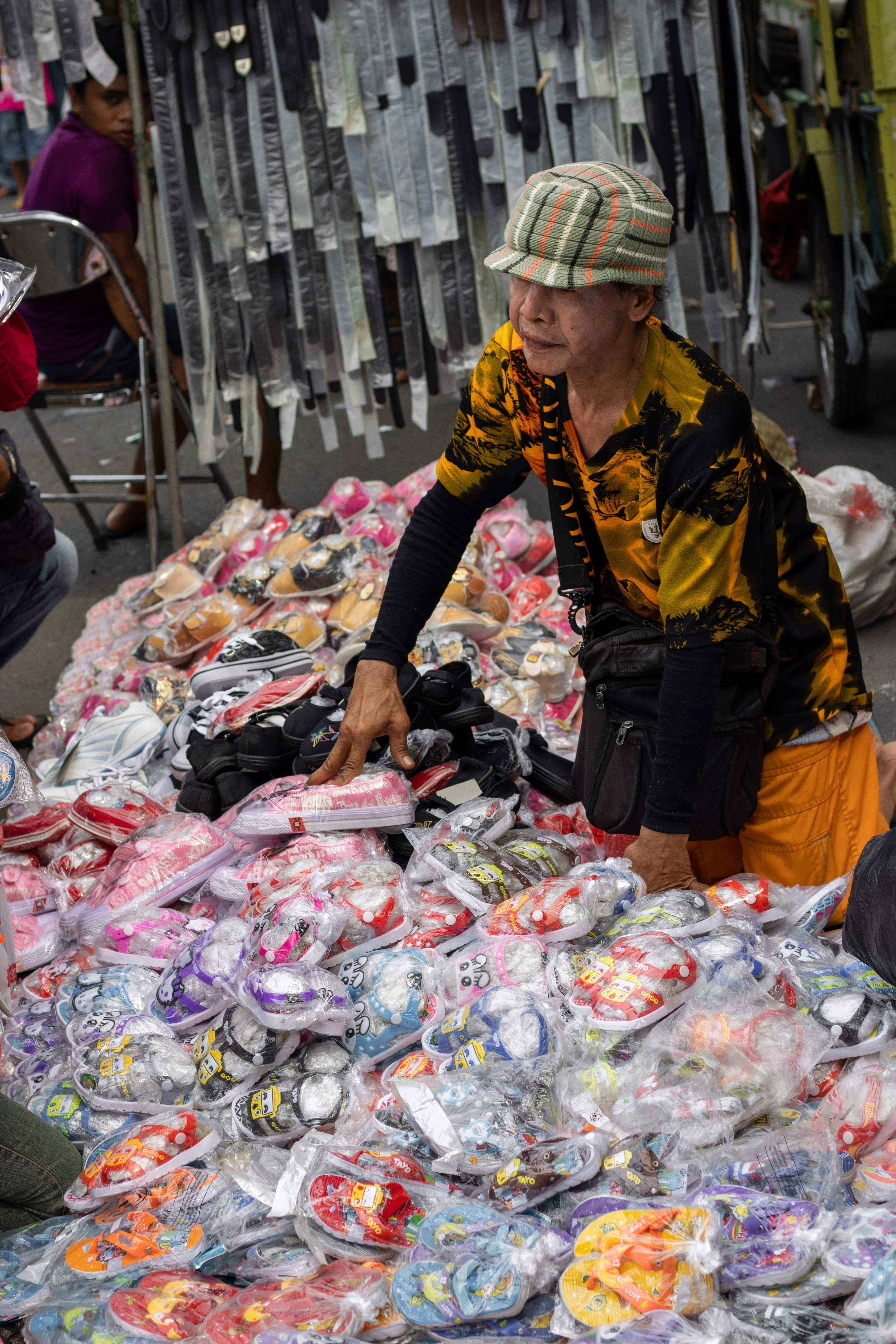 Market Vendor with Colorful Footwear Treasure