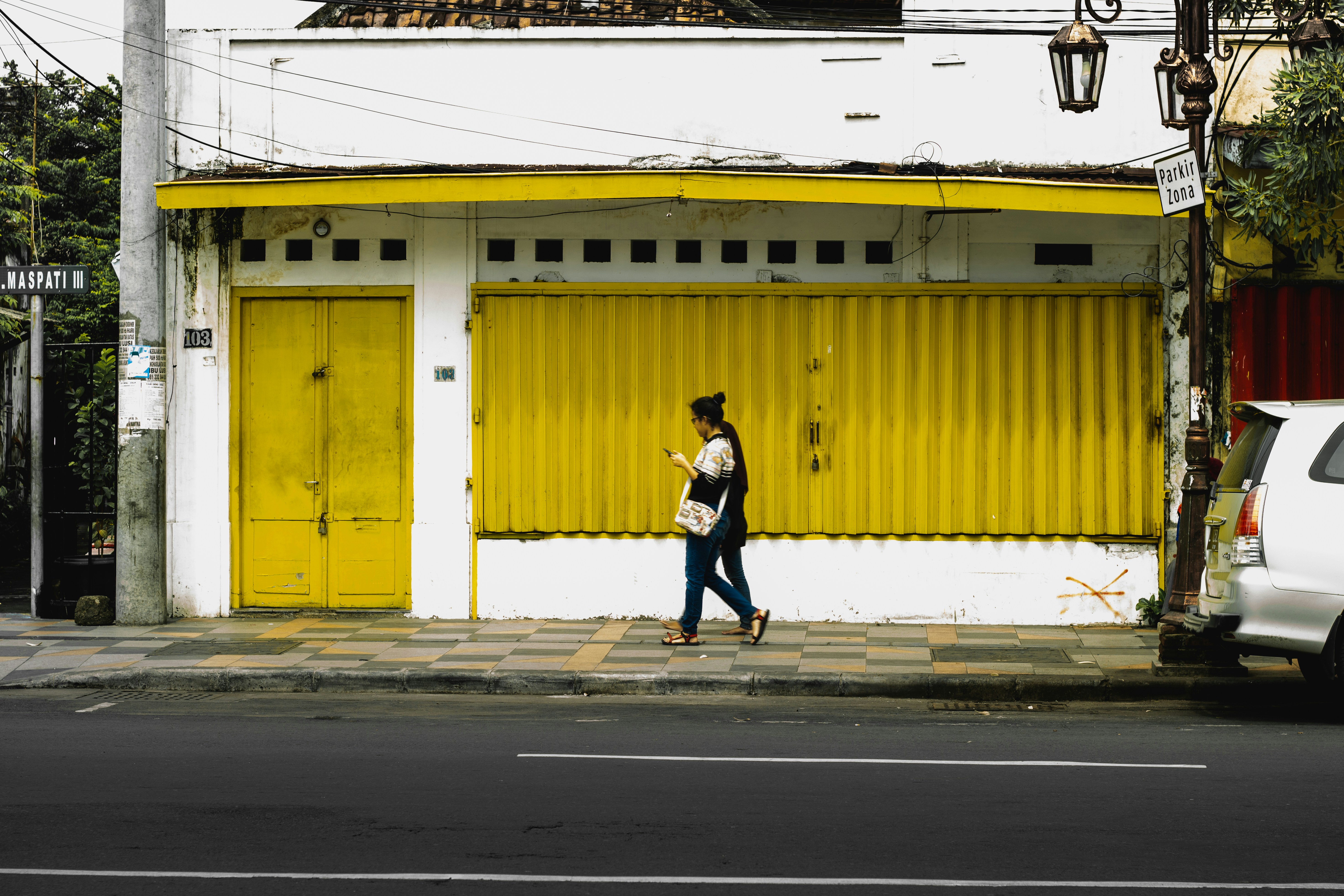 Yellow Gate, Quiet Stride: A Pedestrian Passe of Colorful Street Front