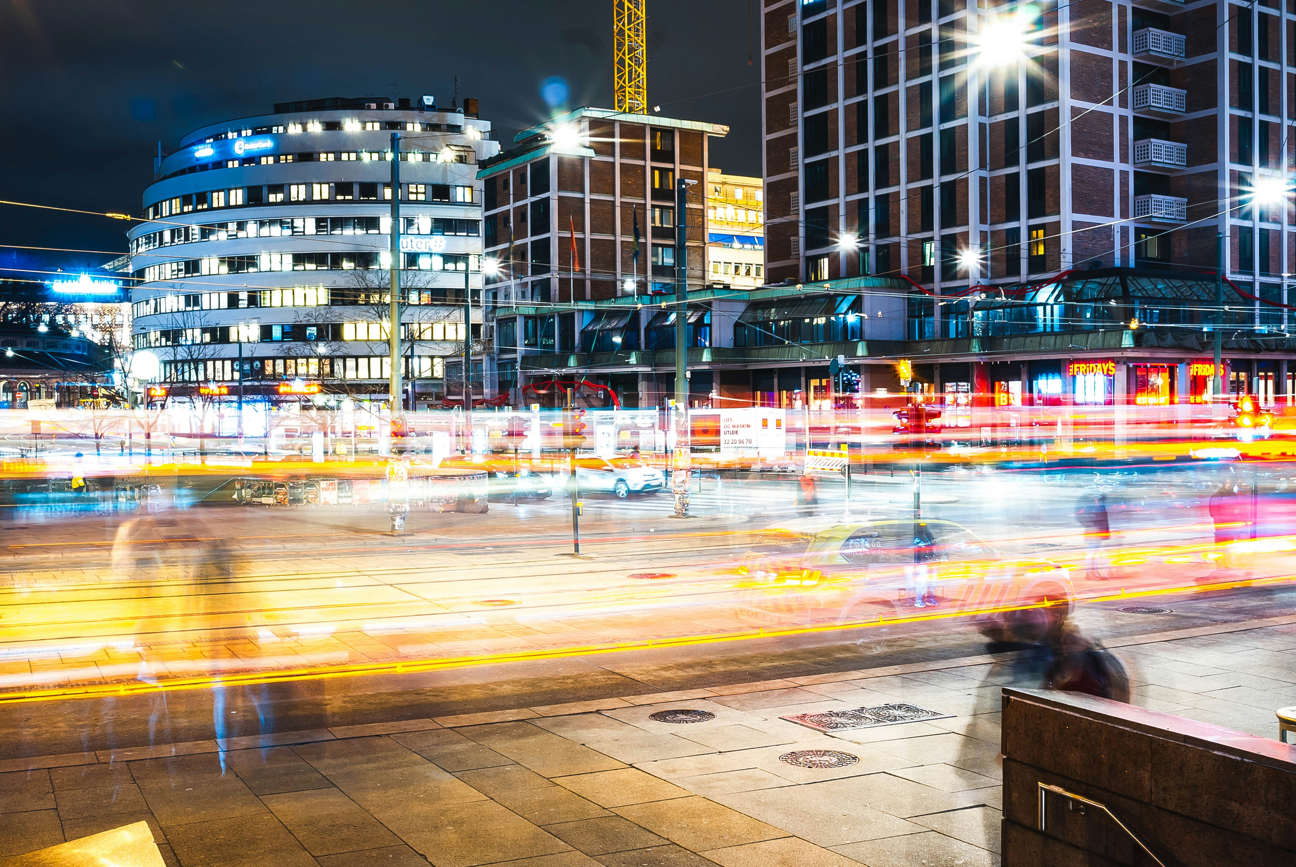 Long exposure of cars creating colorful light trails on a city street at night.