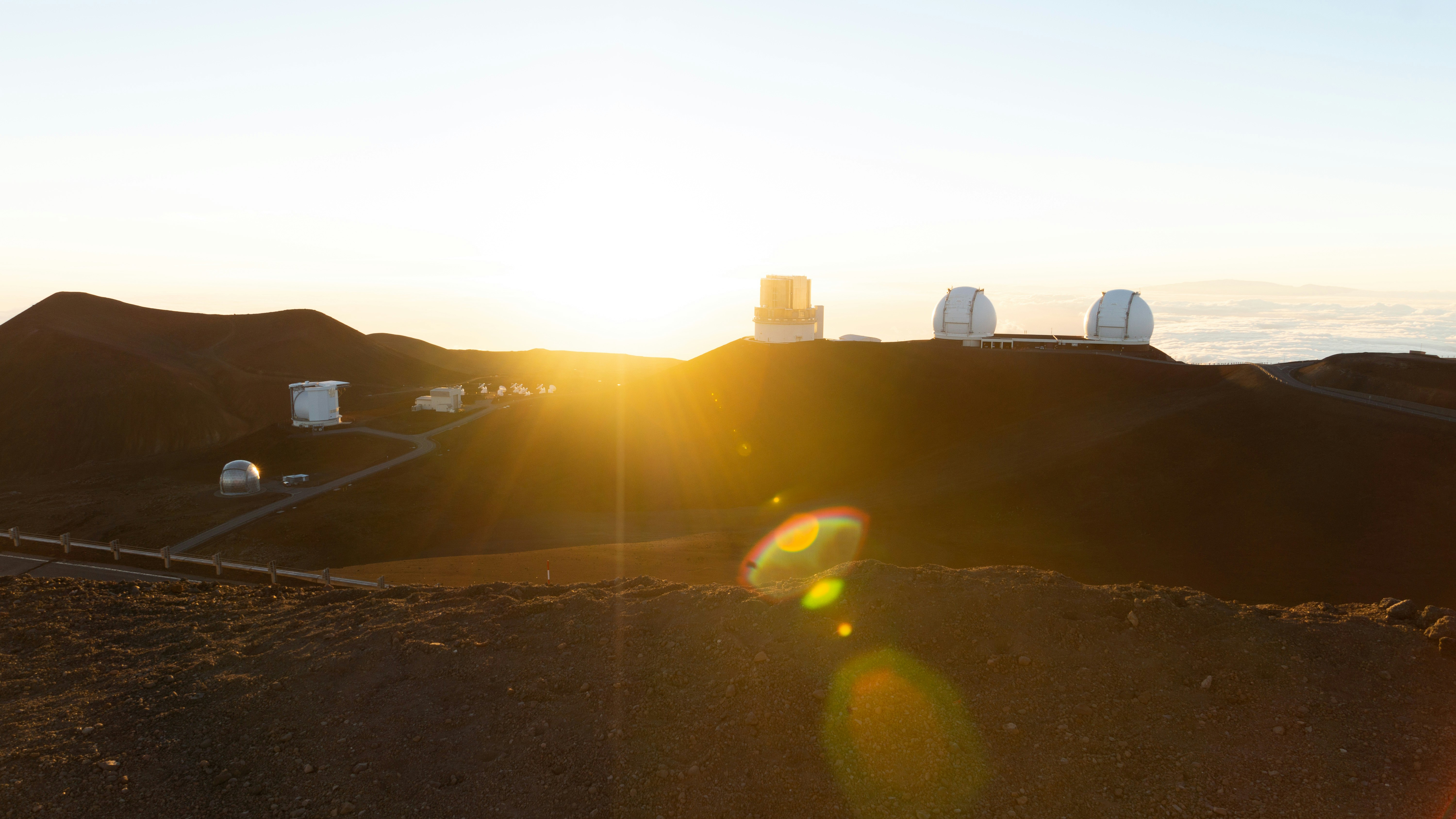 Dawn Over the Observatory Ridge: Sunlit Domes and Lens Flare