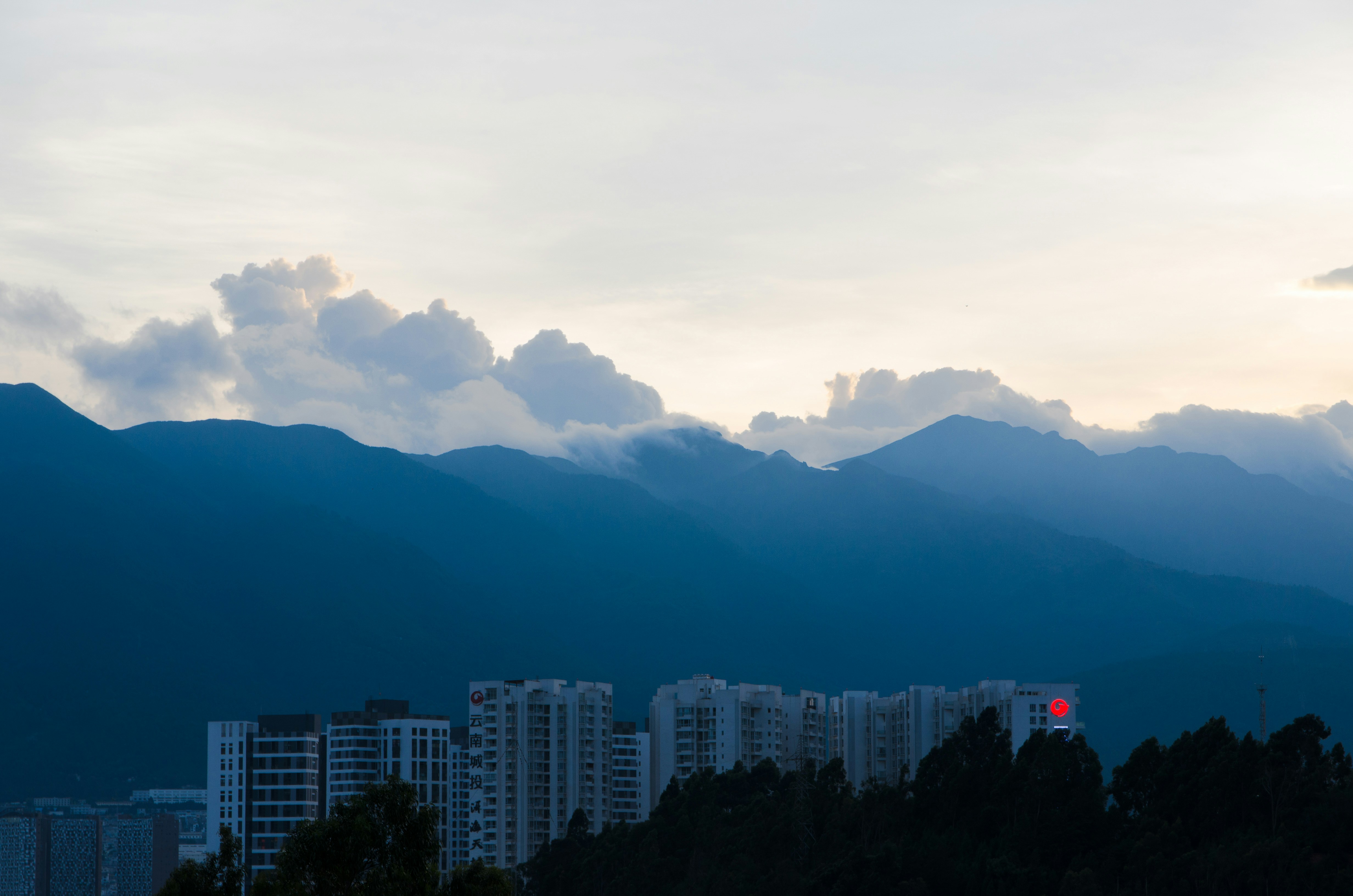 High-rise buildings near mountains photo – Free Blue Image on Unsplash