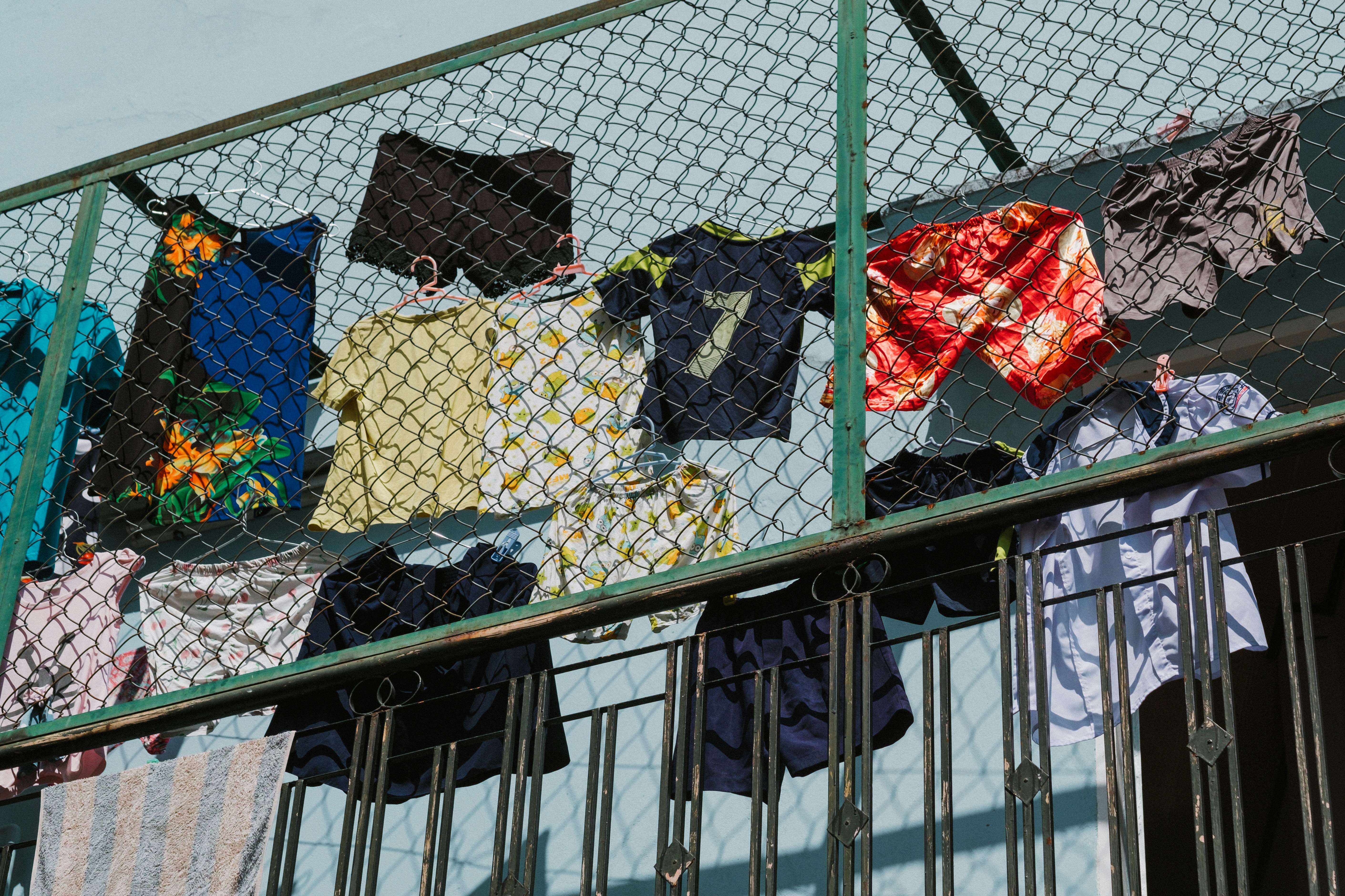 Assorted-color clothes hung on fence photo – Free Railing Image on Unsplash