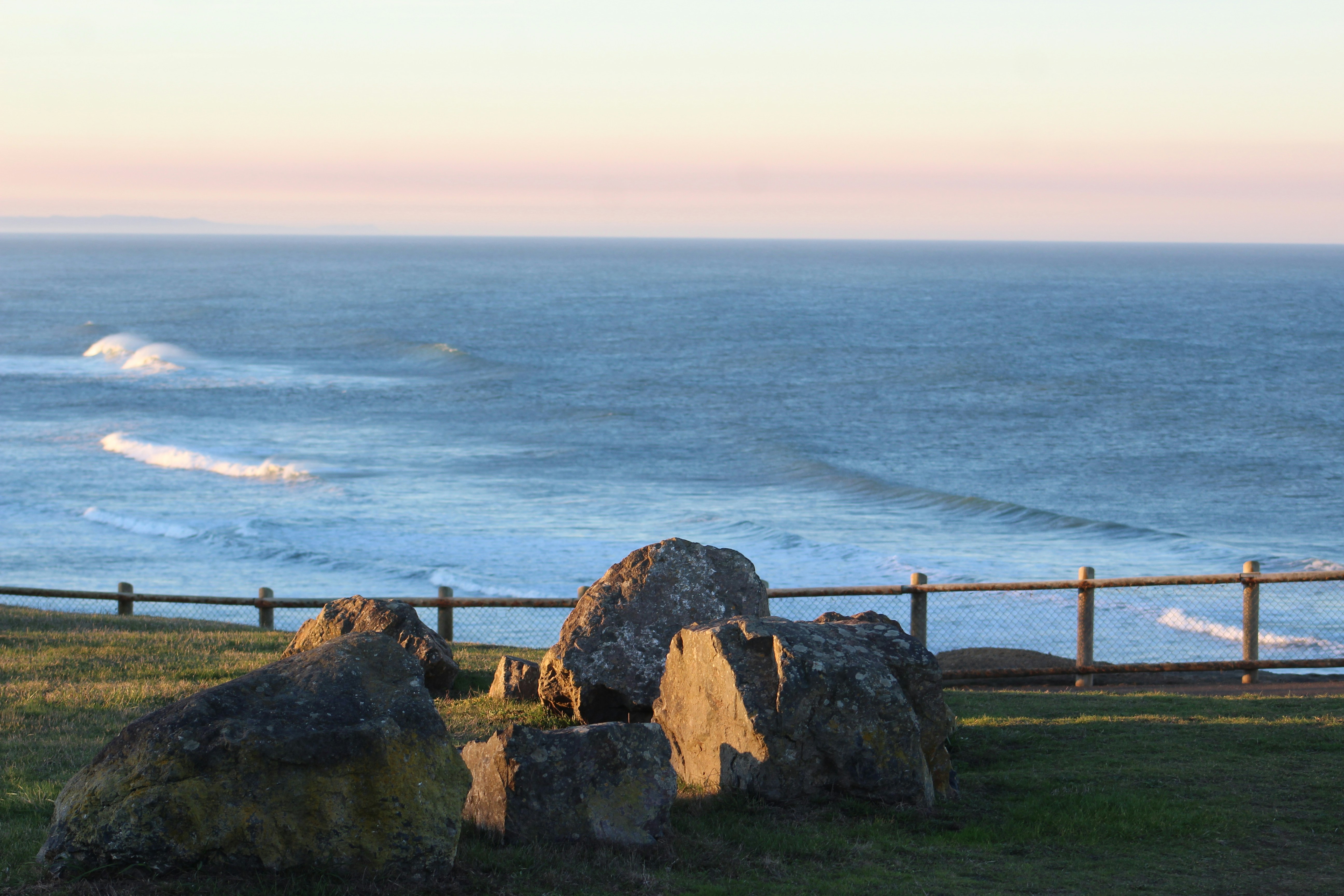 Big rock boulders on grassy field overlooking the ocean photo – Free ...
