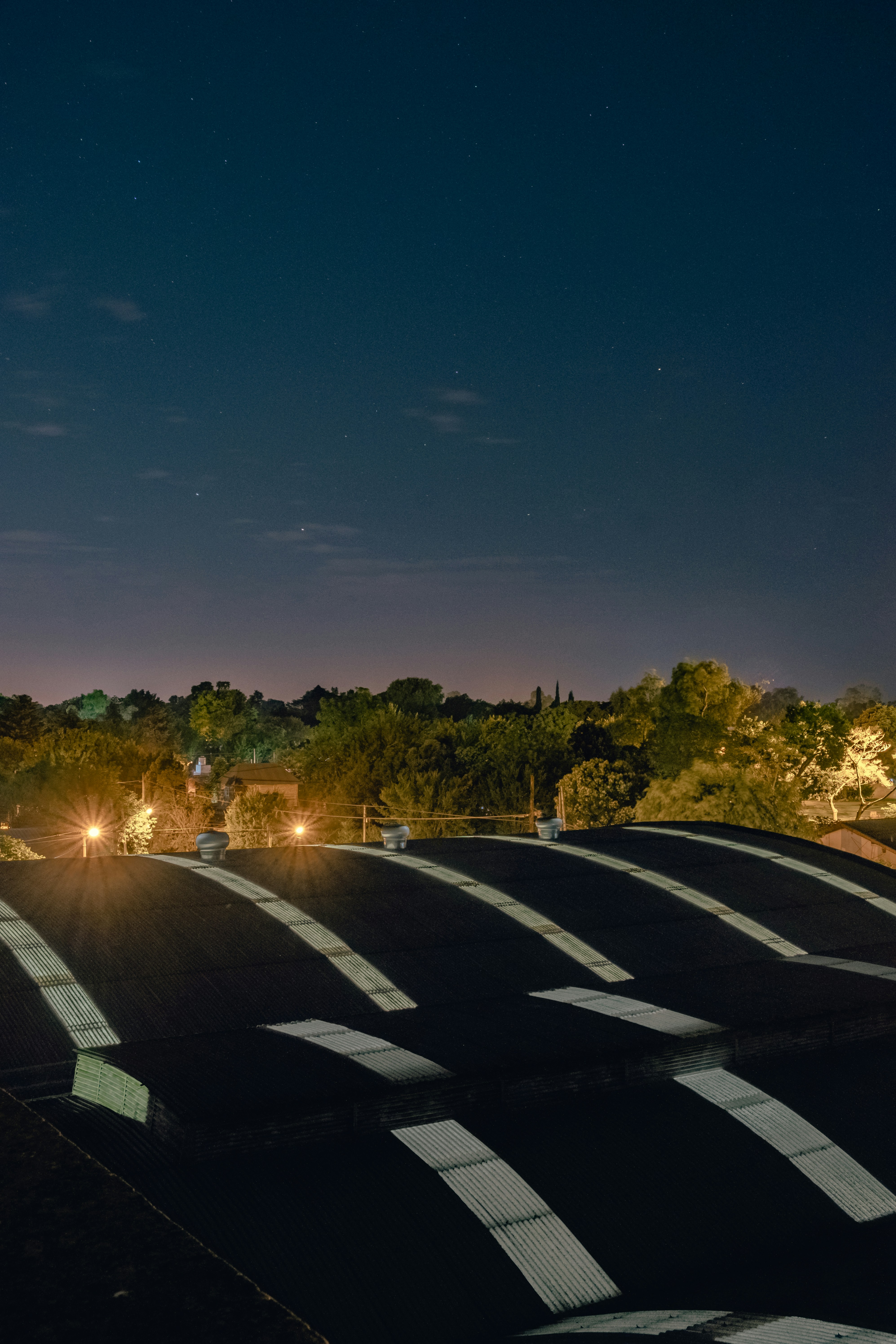Night Drift over the Curved Rooftop: Starry Horizon at the Edge of town