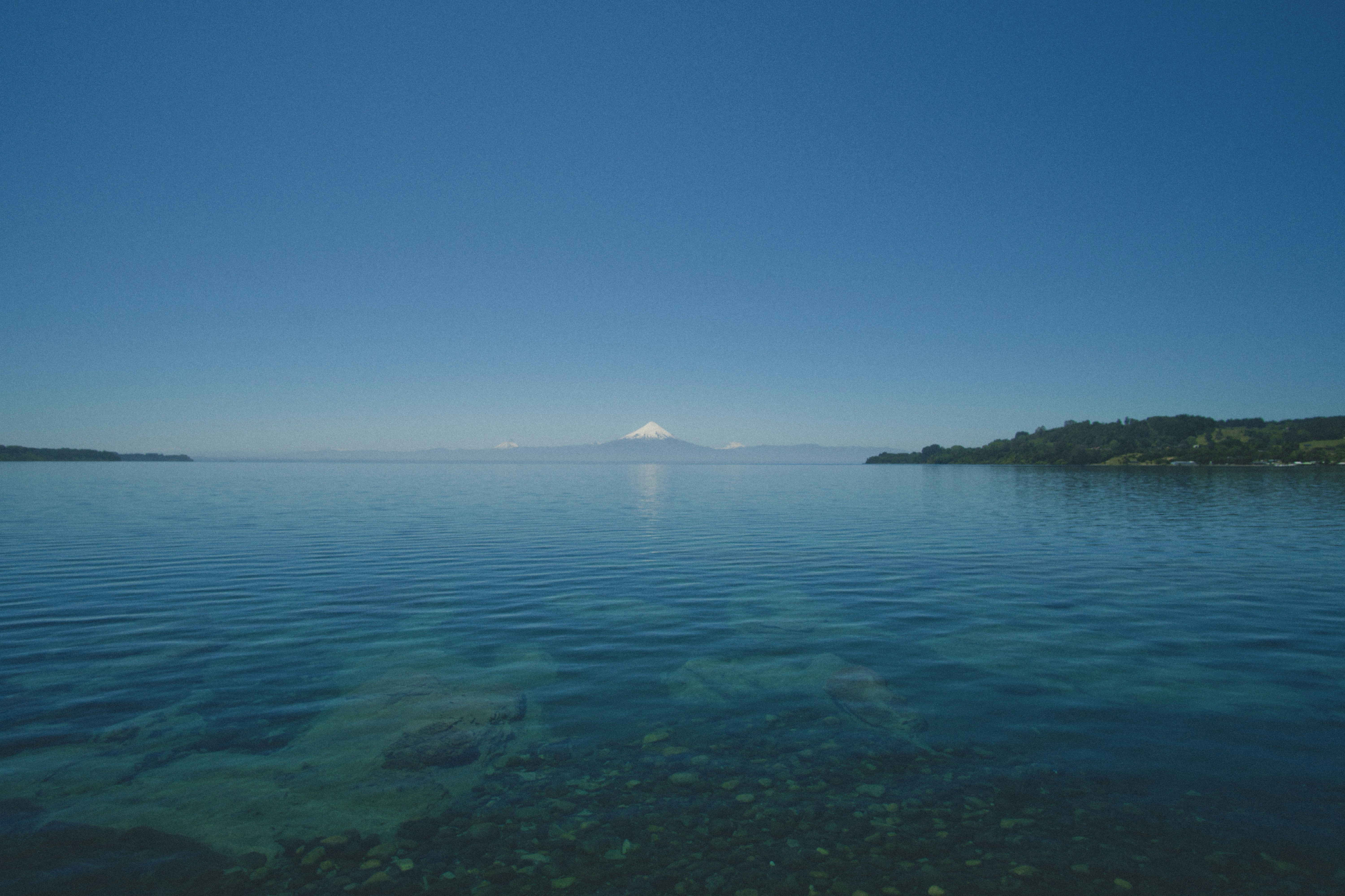 Horizon Peak Emerges Over a Glassy Coastal Expanse