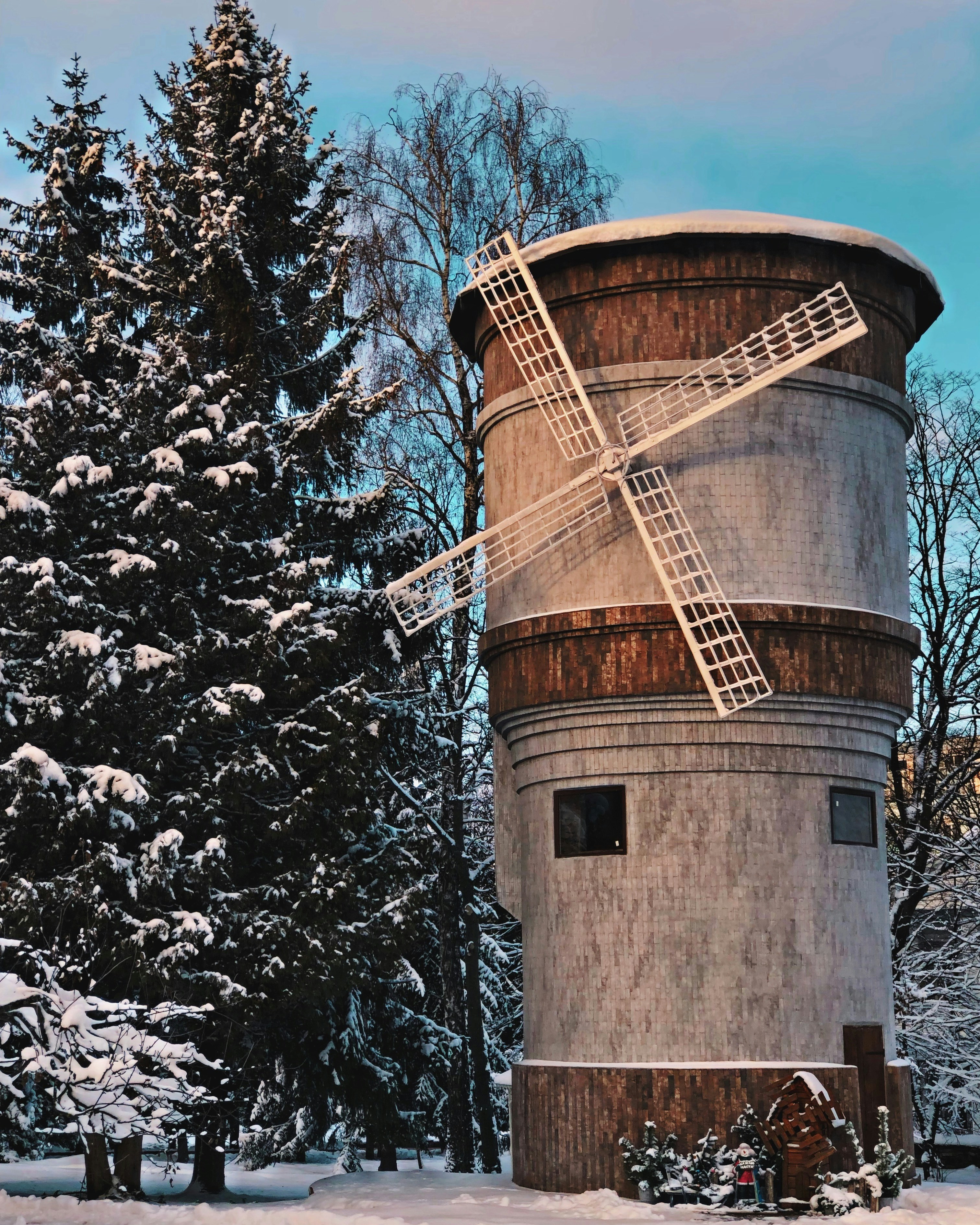 Crosswind Windmill: Snow-White Tower Framed by Frosted Pines