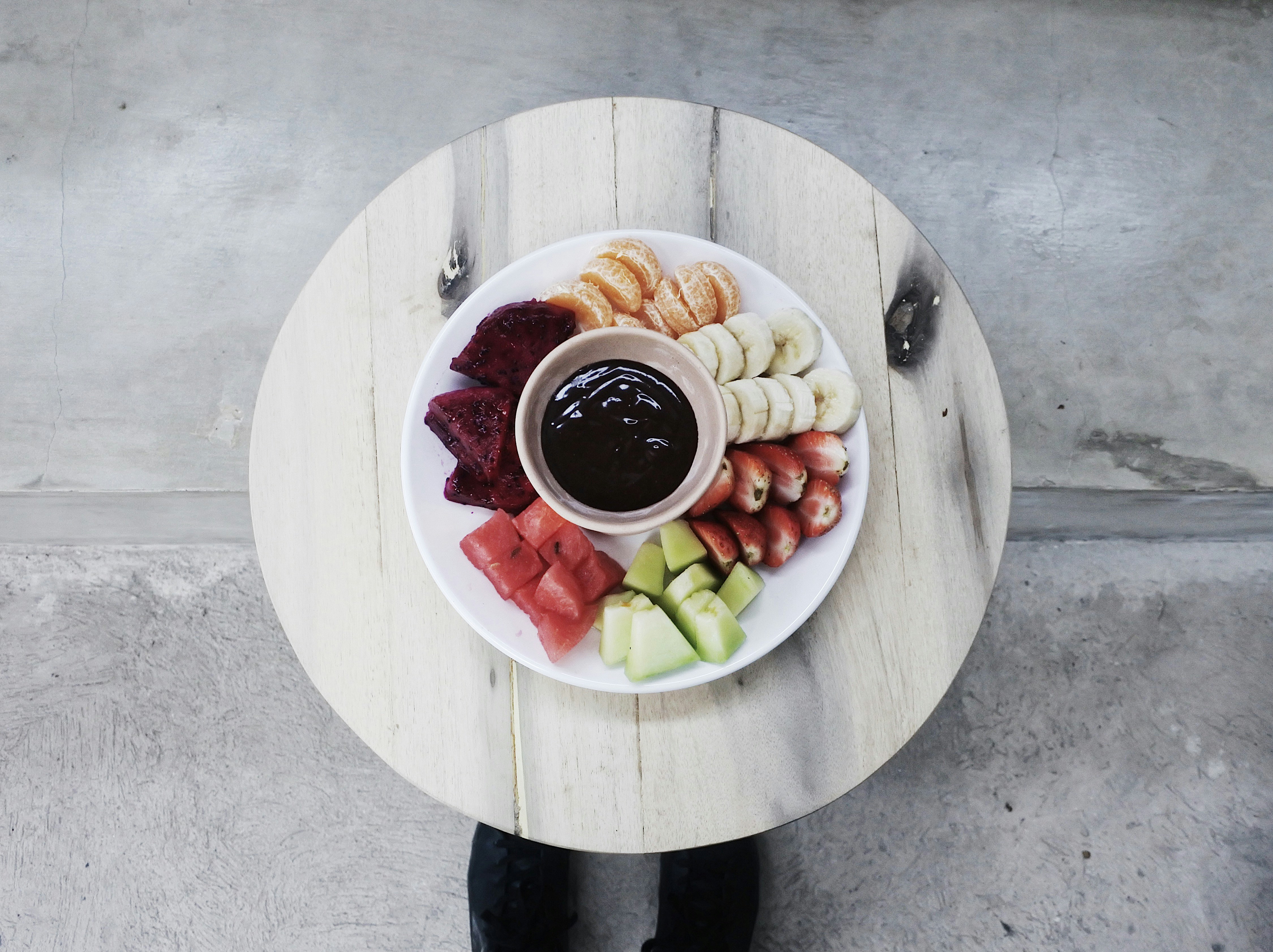 Fruit Platter Centered on a Round Wooden Table