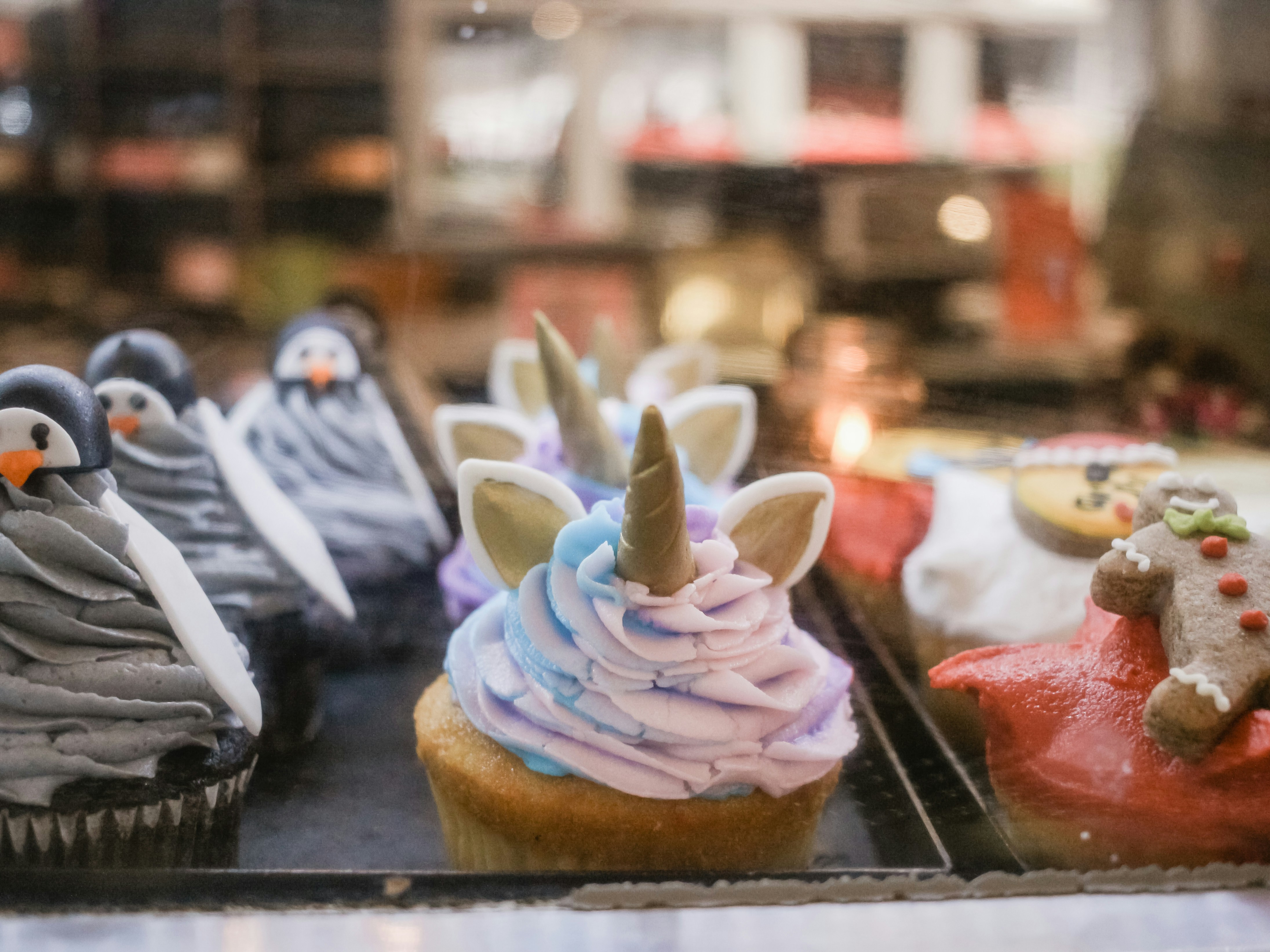 Gold-Horn Unicorn Cupcake Dominates a Tray of Festive Treats
