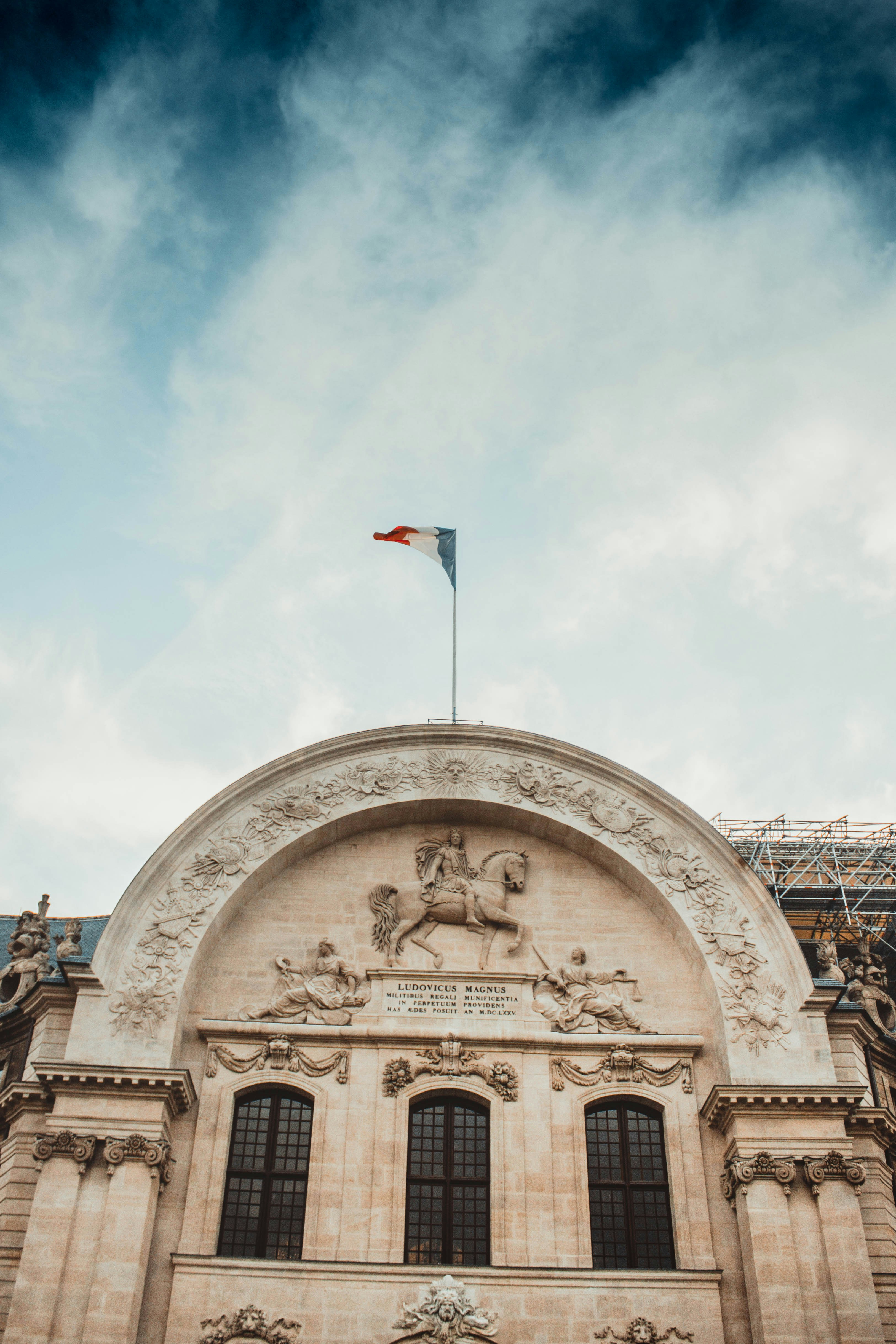 Flag atop the monumental façade: a carved triumph over stone