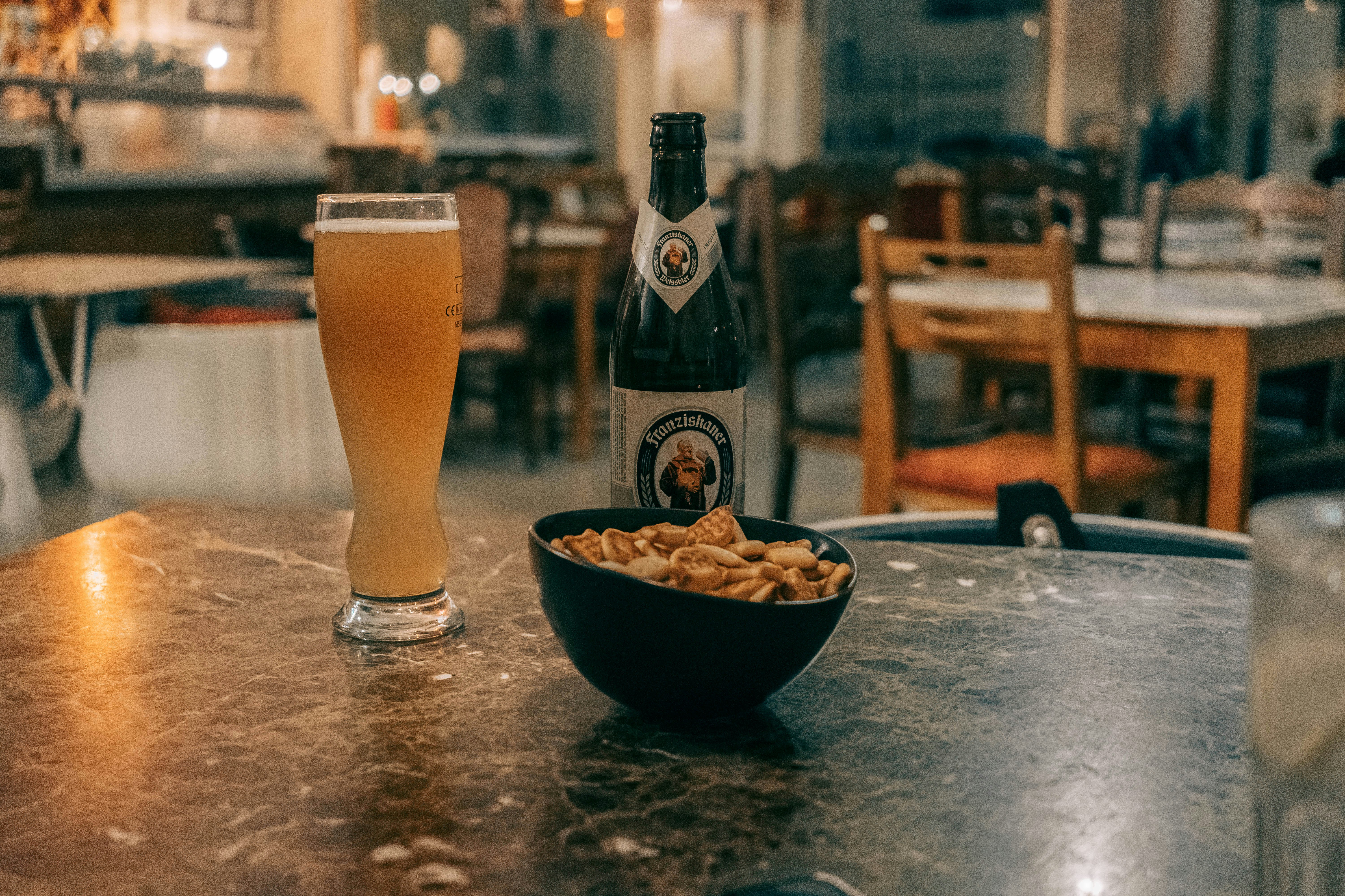 Amber Glass, Bottle, and Nut Bowl: A Marble-Bar Evening Scene