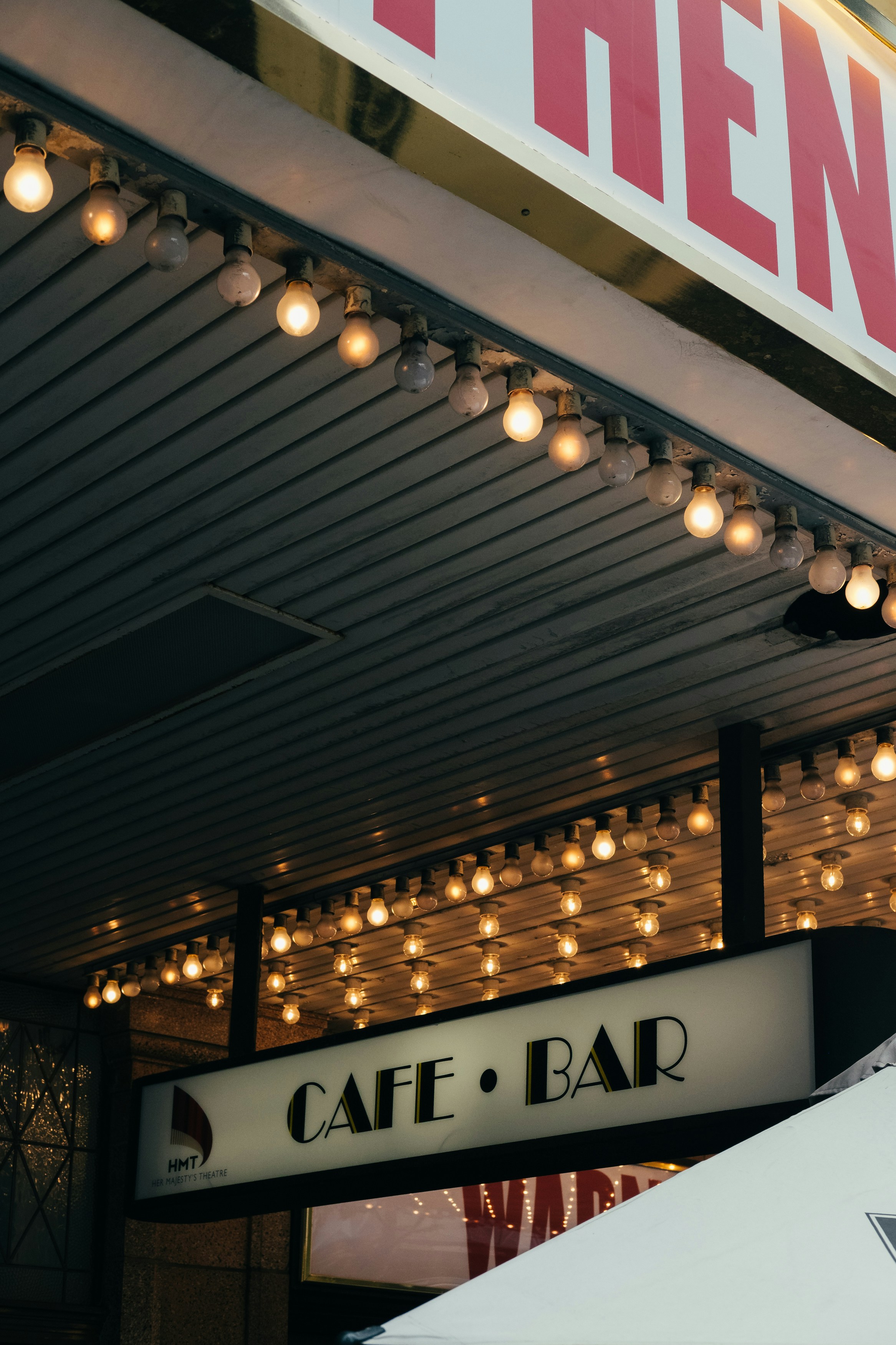 Marquee Lights Over a Café-Bar Facade at Dusk