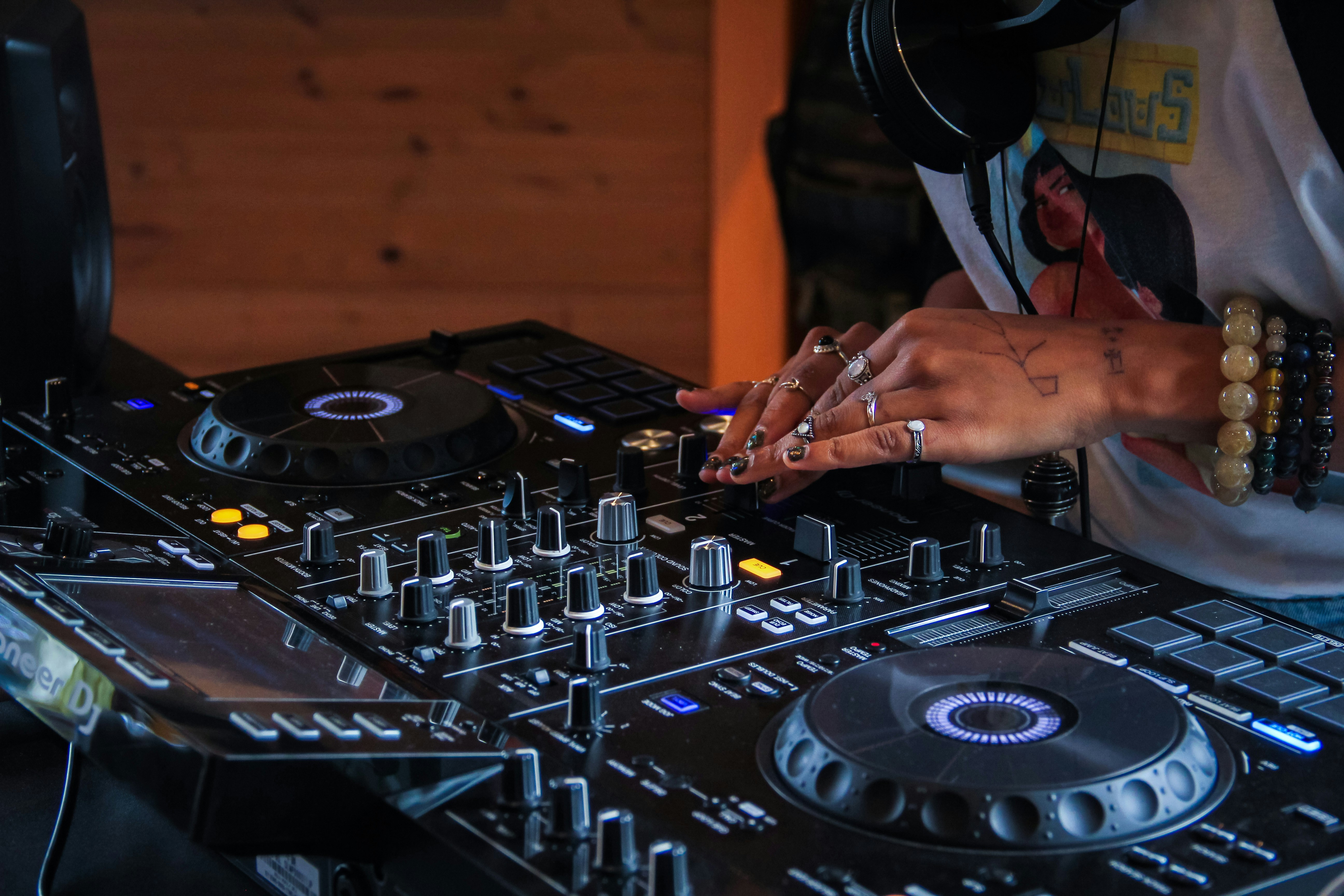 DJ mixing tracks on an intricate console with glowing dials and sliders.