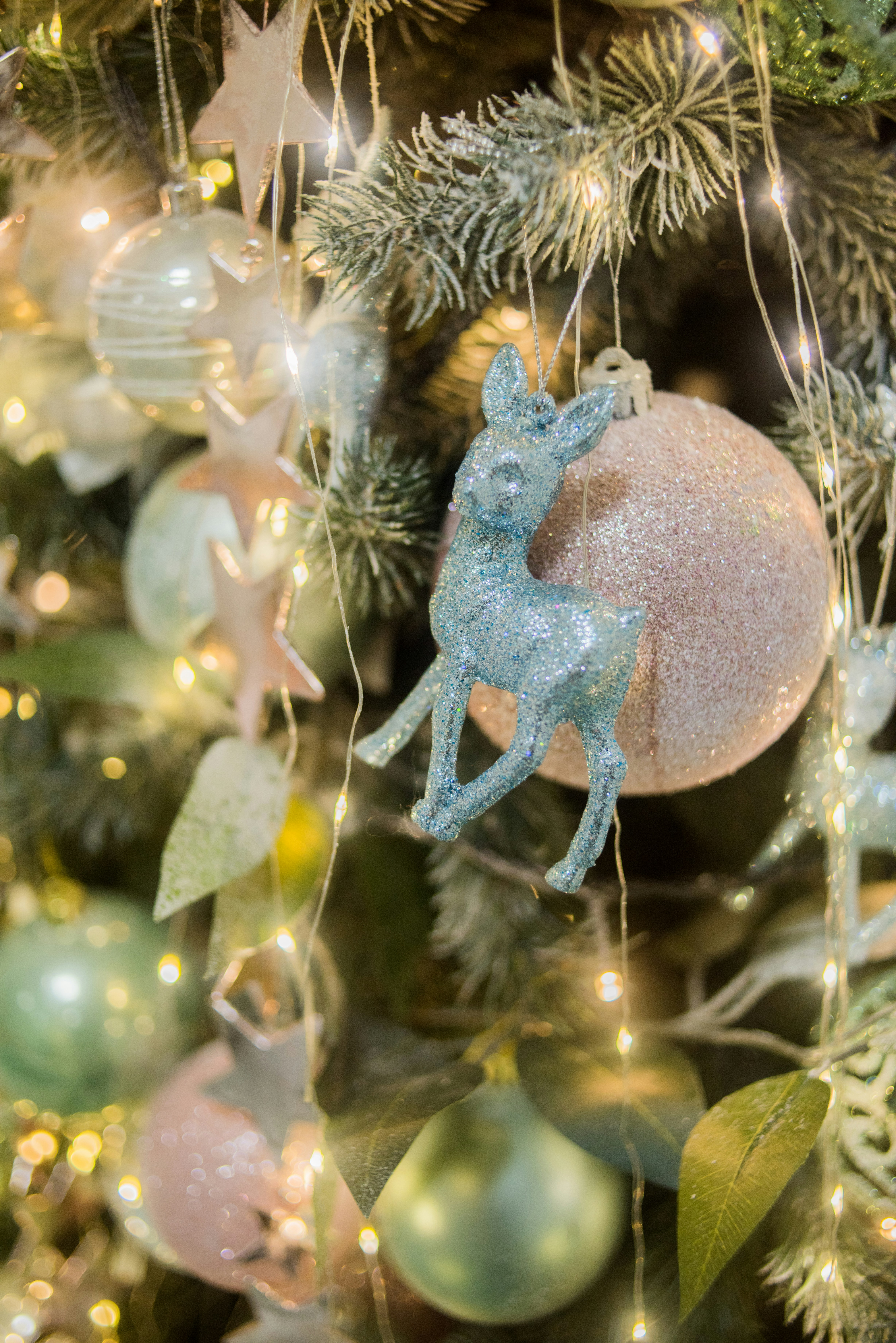 Blue Glitter Reindeer Dangles Amid Soft Christmas Lights