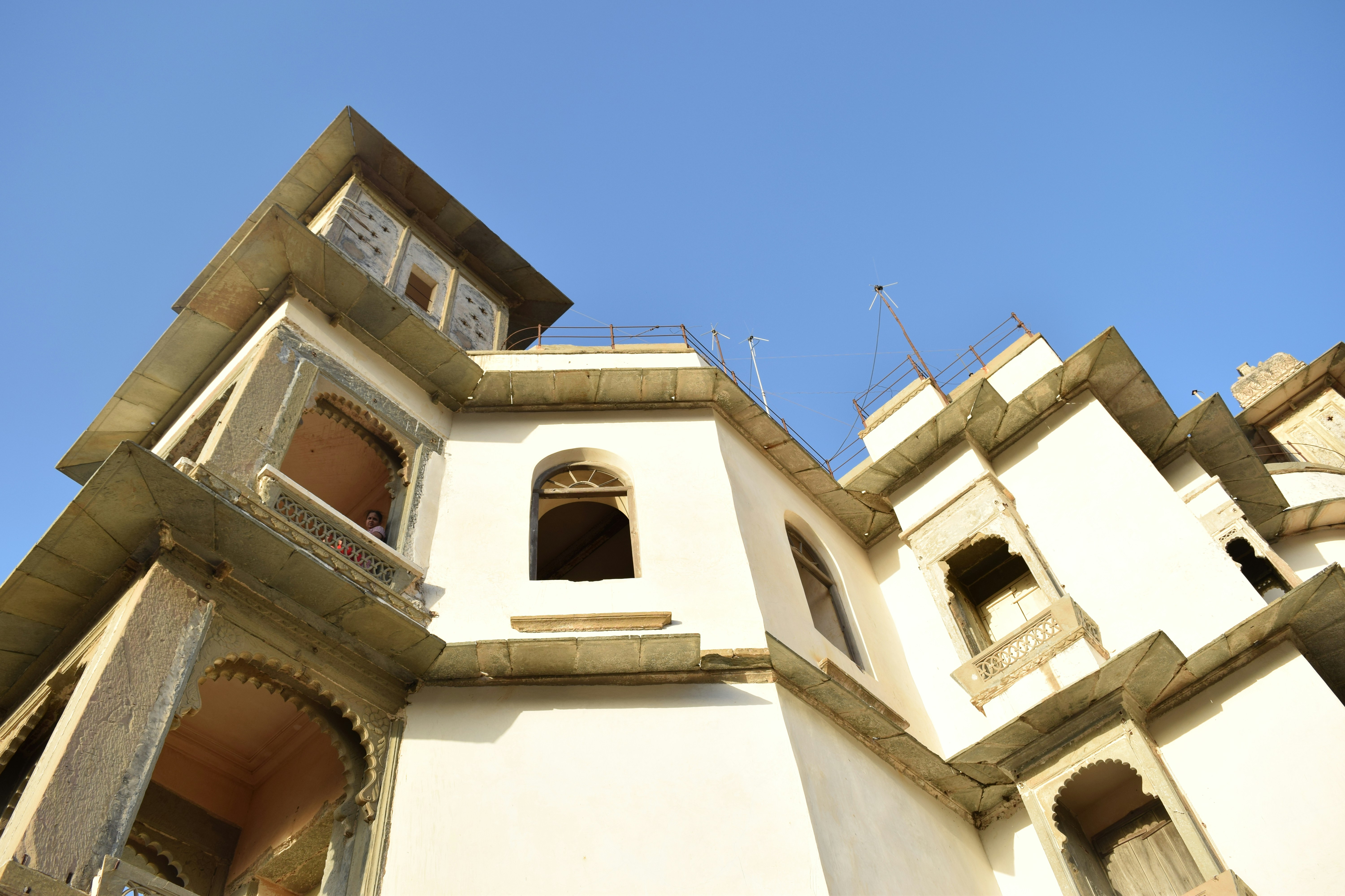 Intricate details of a historic building under a clear blue sky, showcasing its unique architectural features and textures.