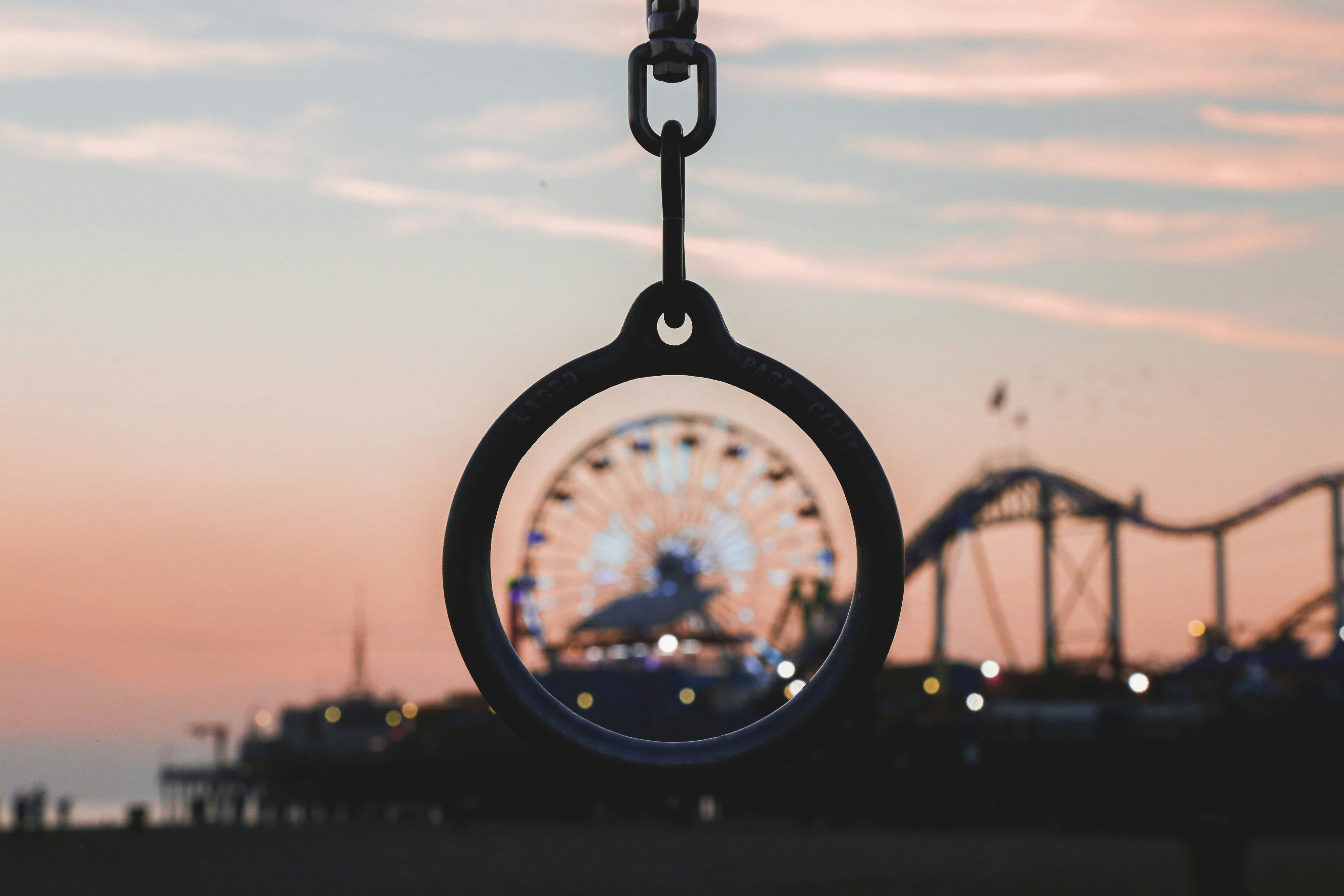 Frame Within a Frame: Ring Anchors a Sunset Pier and a Blurred Ferris Wheel