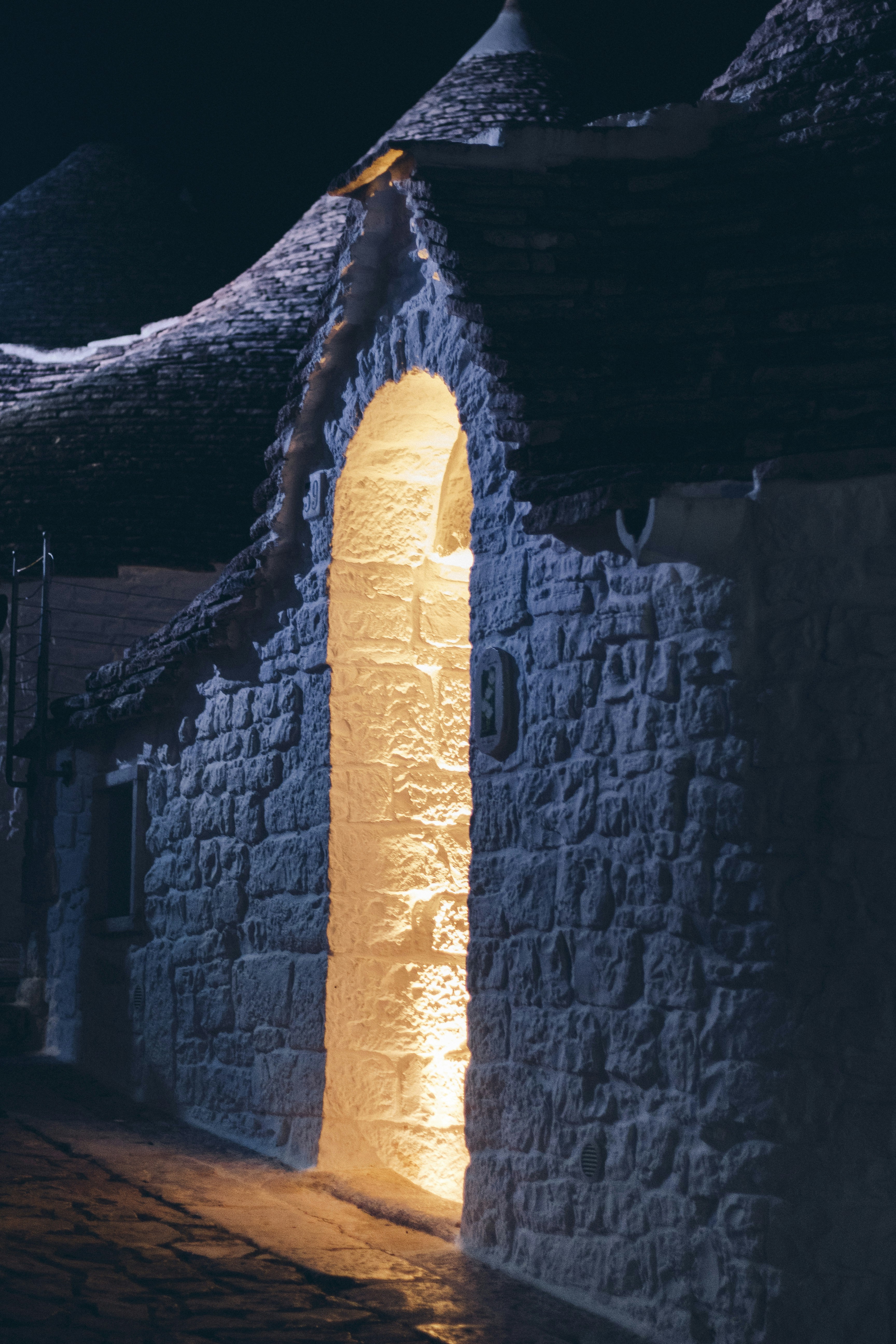 Glow Between Stones: A Warm Archway in Moonlit Village