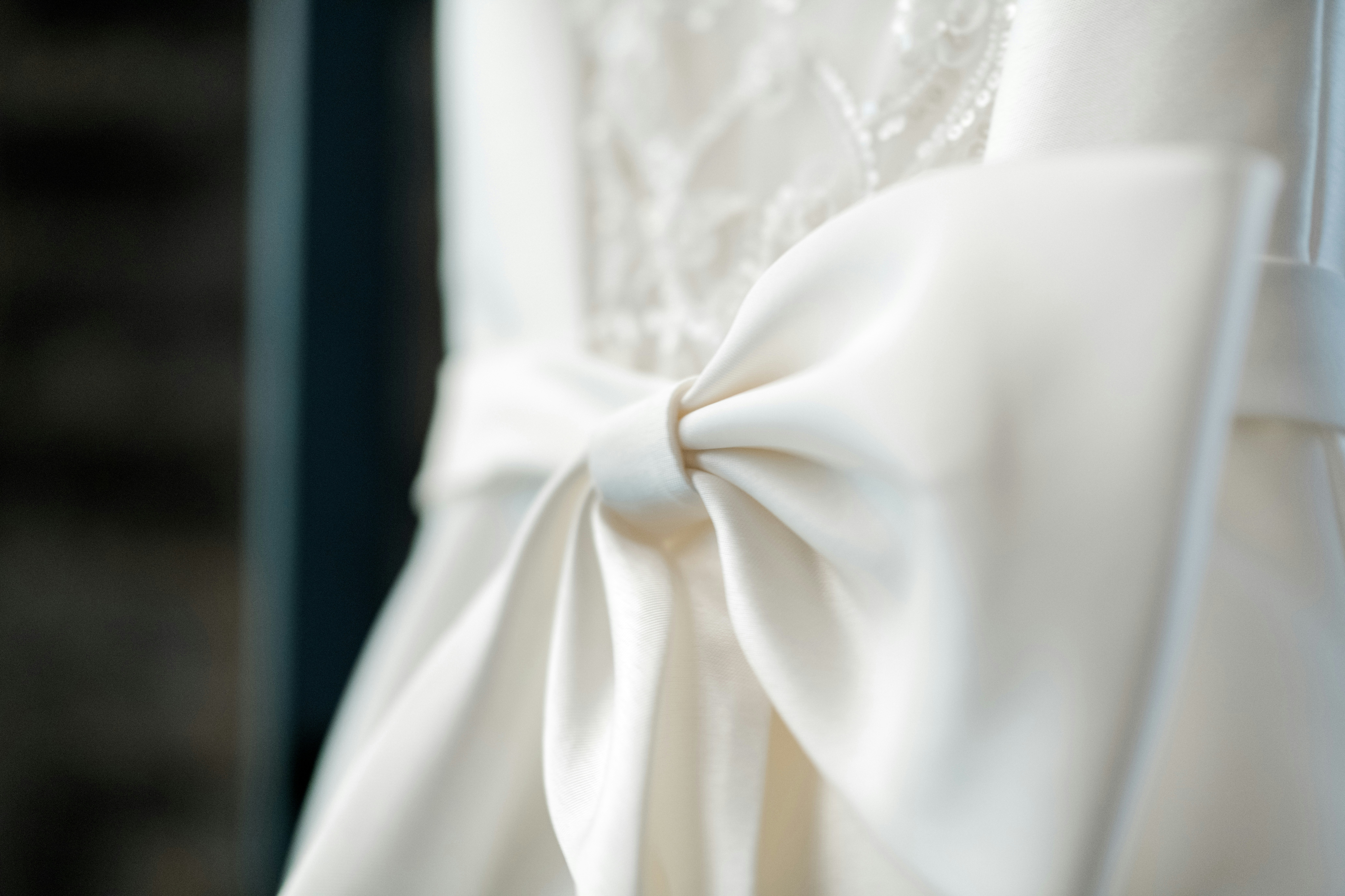 Close-up of a delicate wedding dress bow, highlighting intricate fabric details and texture.