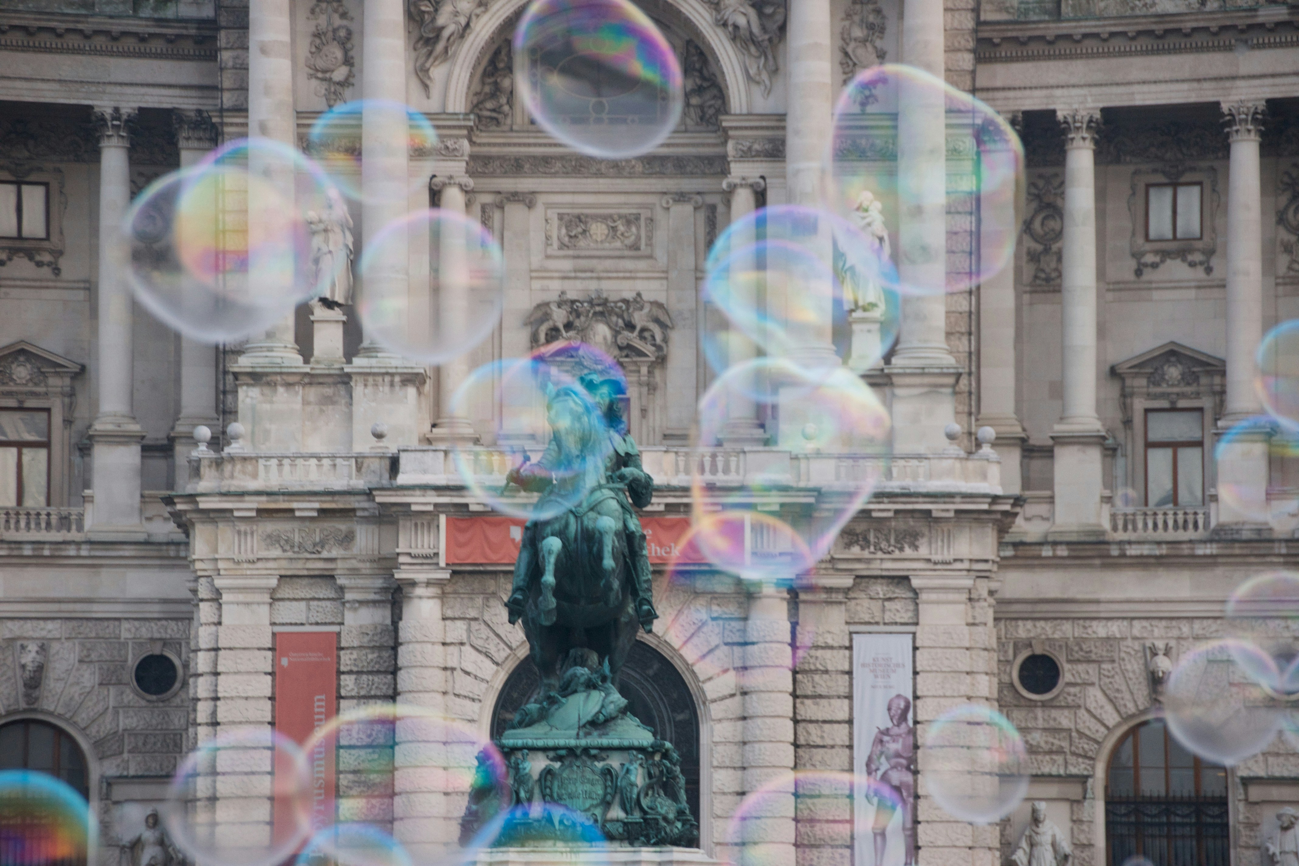 Bubbles Over the Facade: A Statue Framed by Translucent Orbs