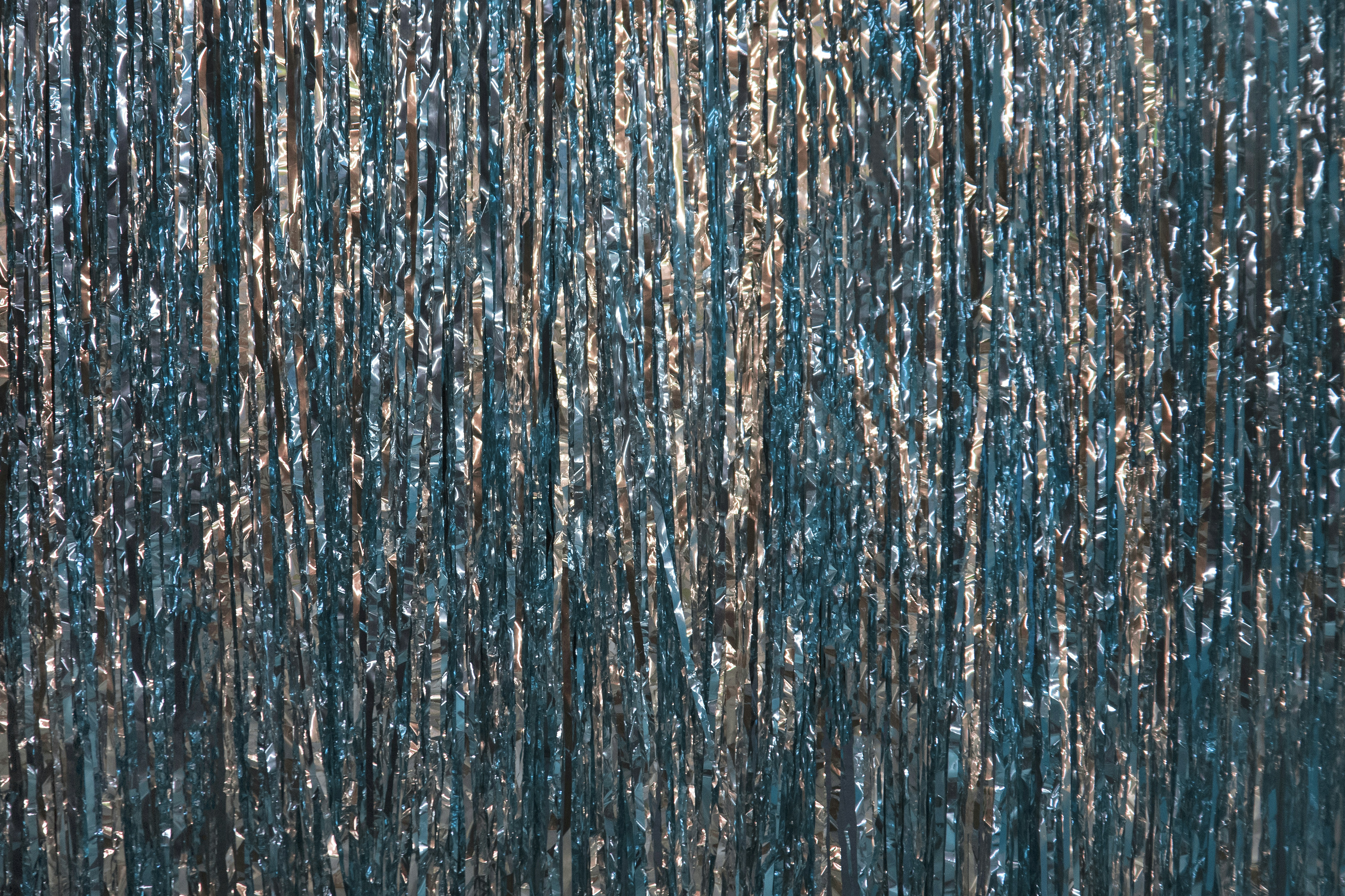 A vibrant backdrop of metallic blue and silver strands creating a dynamic texture. The interplay of light enhances the visual depth.