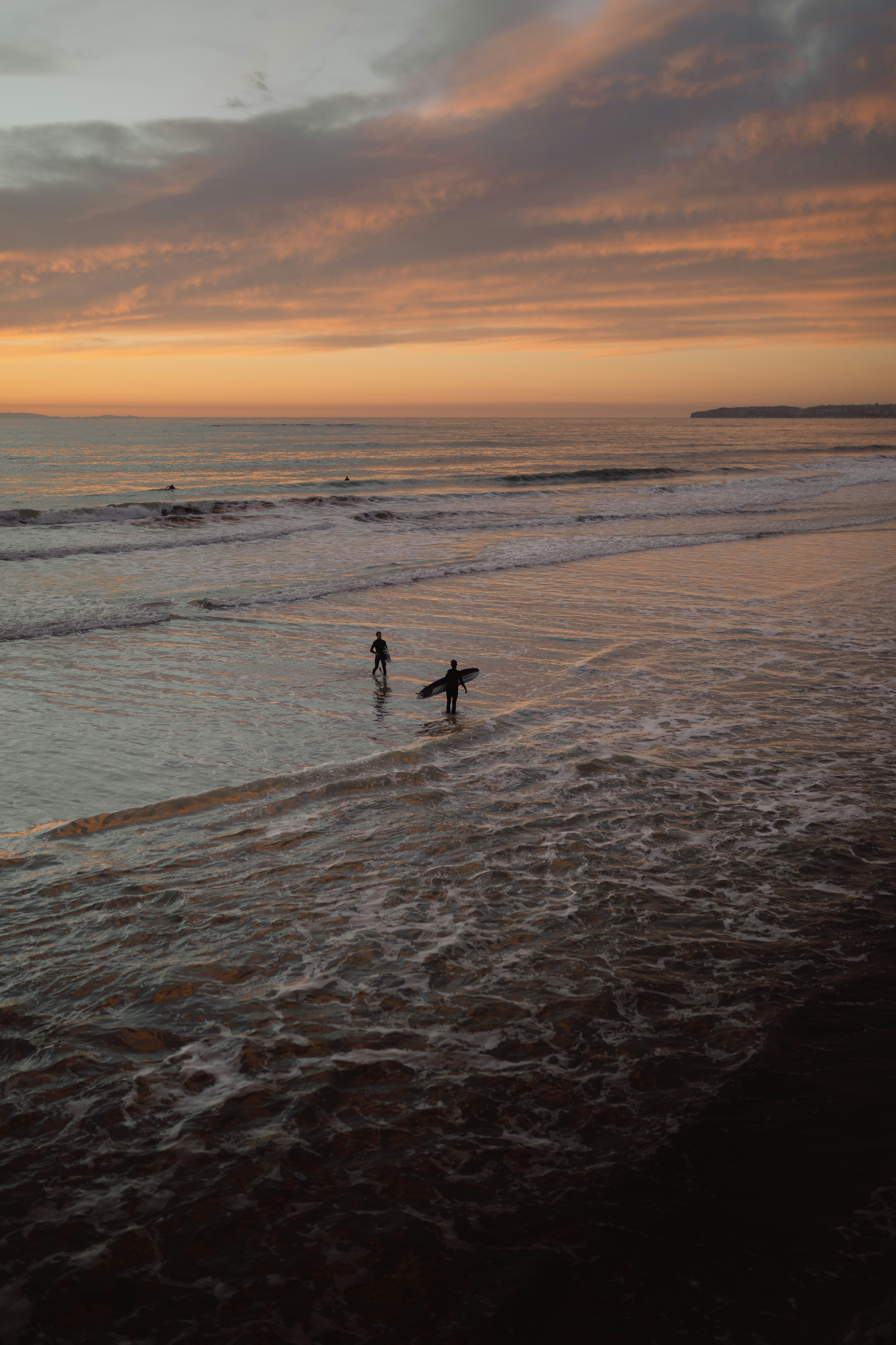 Golden Hour Glide: Surfers at the Gentle Shore