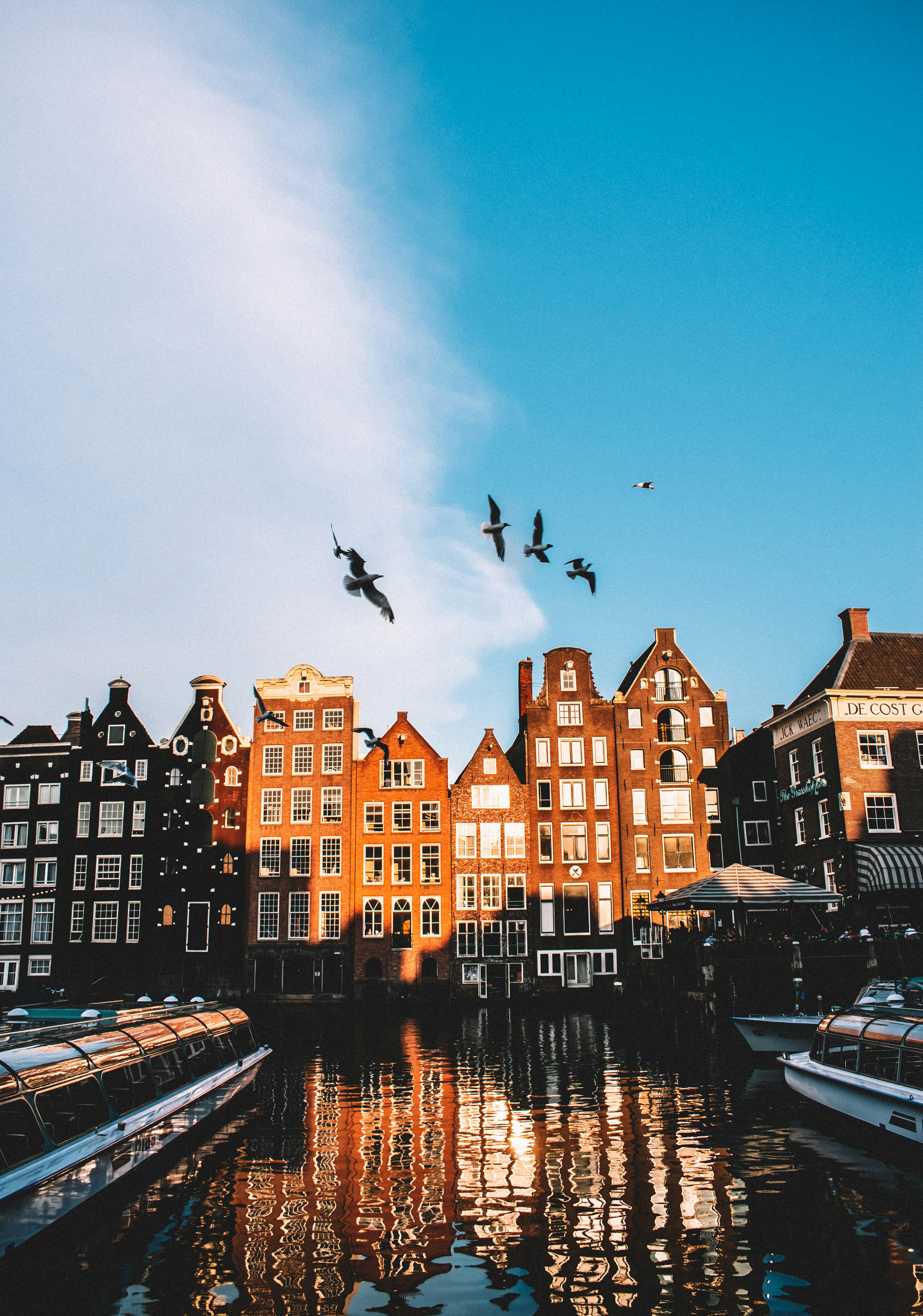 Amber Facades Along an Amsterdam Canal: A Gabled Row in Quiet Light