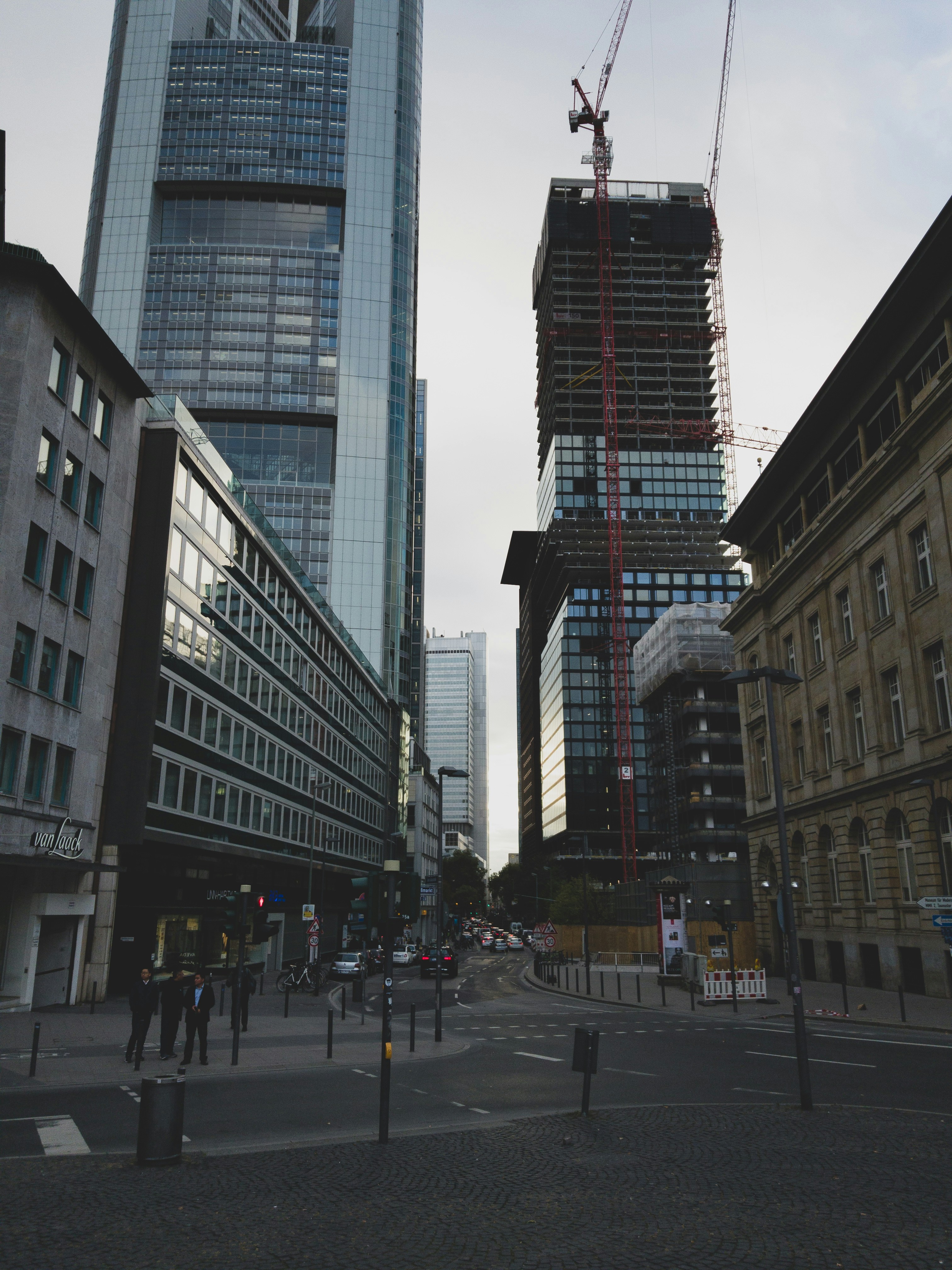 Crane's Red Spine Between Glass Giants