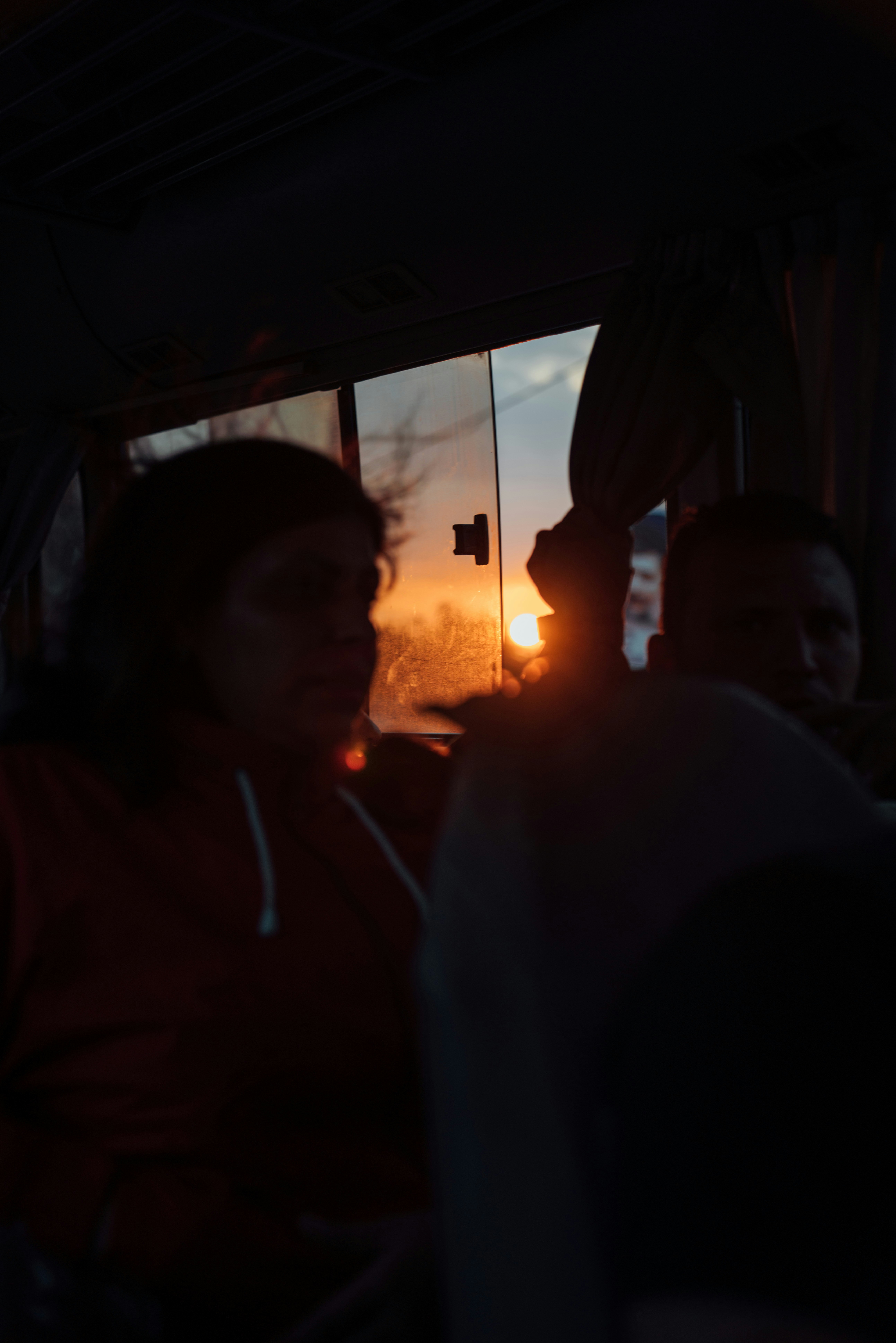 Sunset Window Moment: Orange Glow Between Silhouetted Passengers