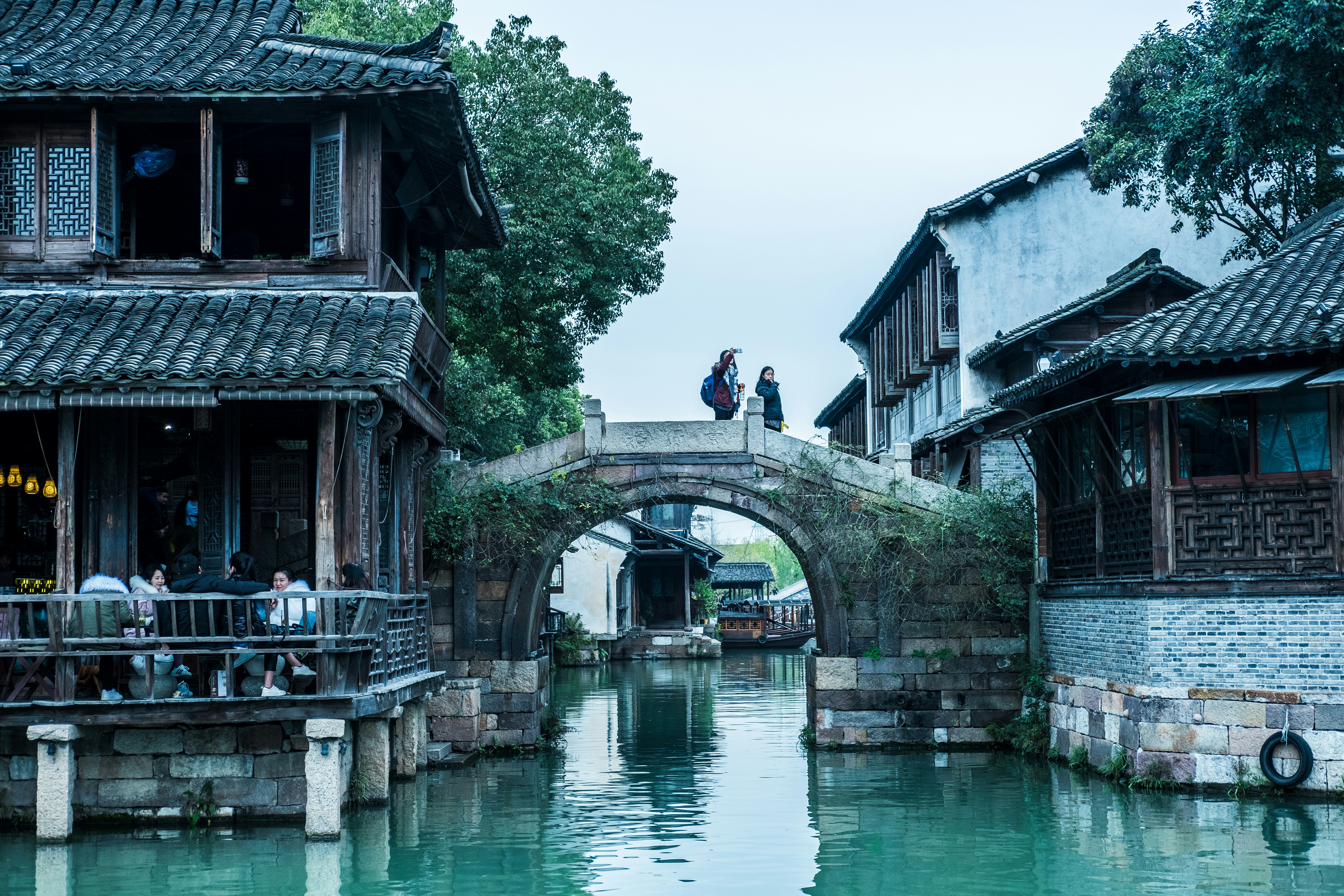 Two person standing on bridge in between of buildings photo – Free ...