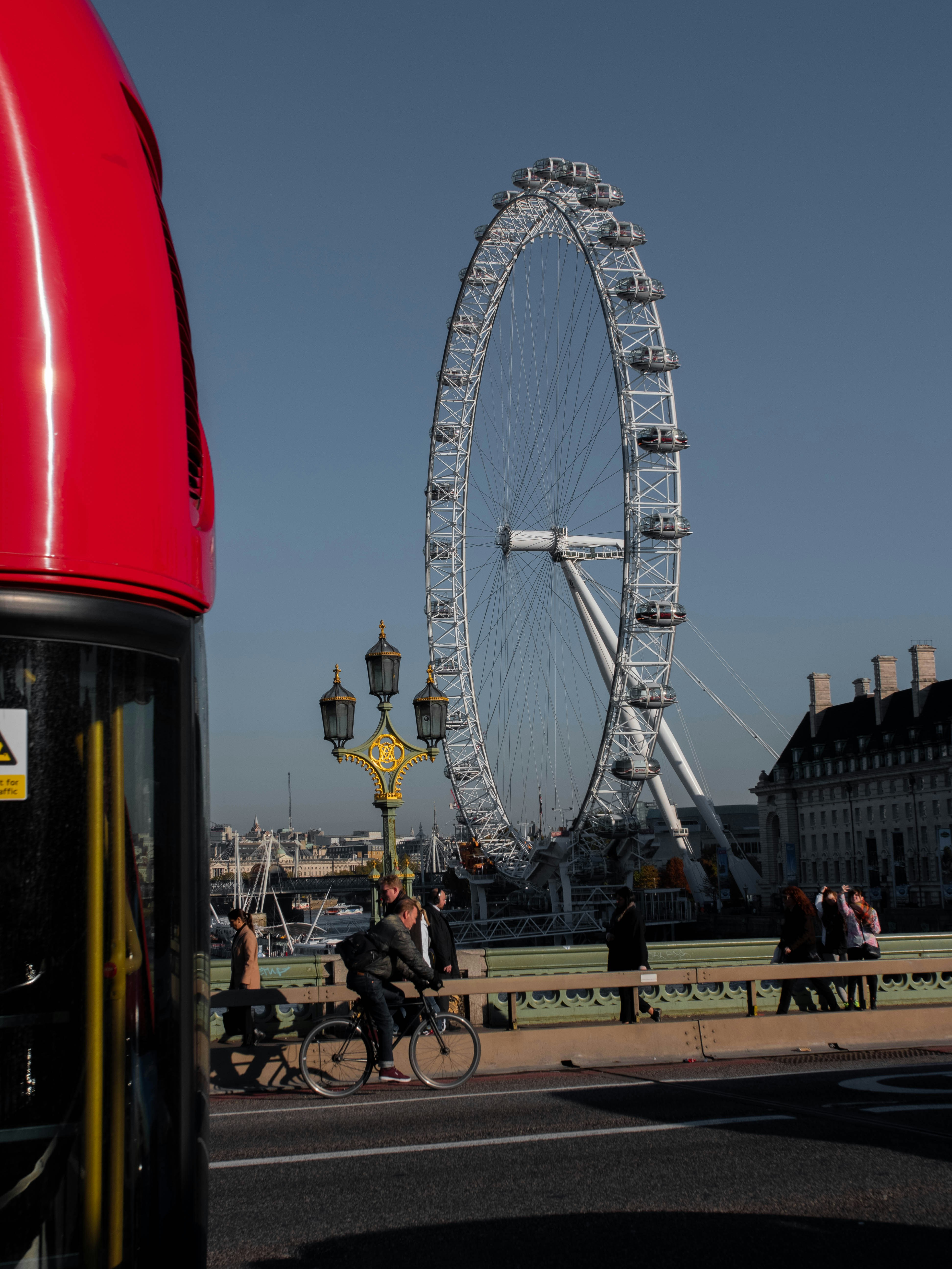 London Eye in Focus: Red Bus, Bicyclist, and Fogless Skyline