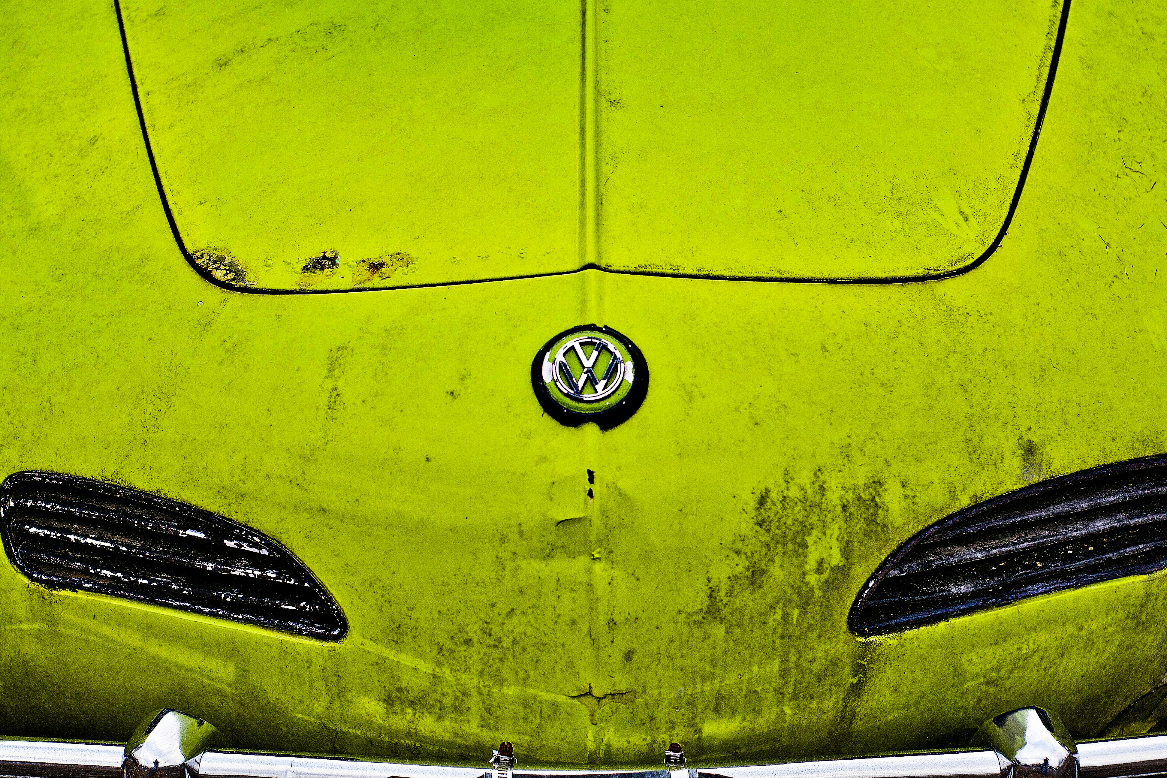 Neon Beetle: Lime VW Badge Beneath Weathered Grille