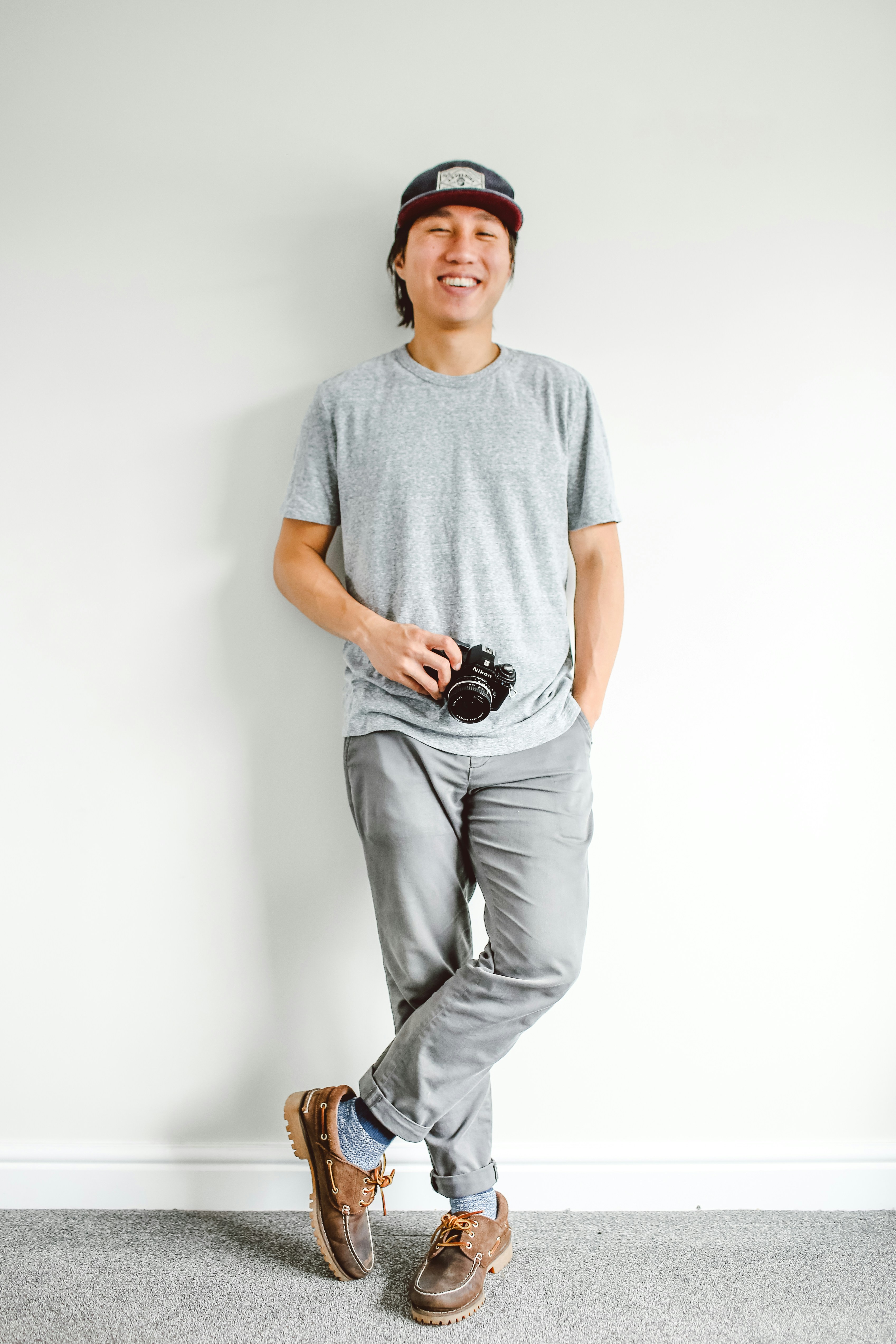 Man standing and leaning by wall while holding camera photo – Free ...