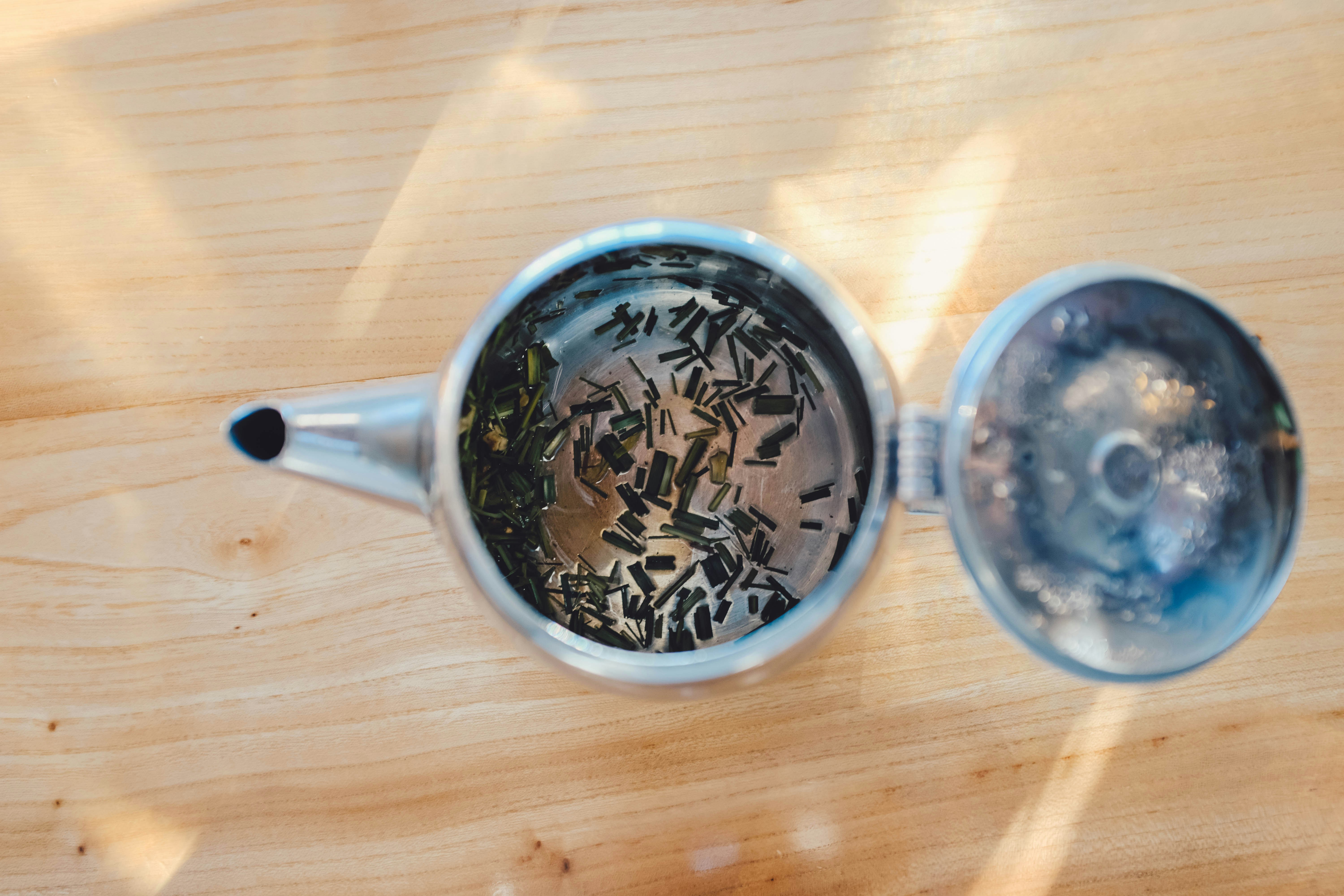 Sunlit Top-Down Teapot: Leaves Adrift in a Metallic Vessel