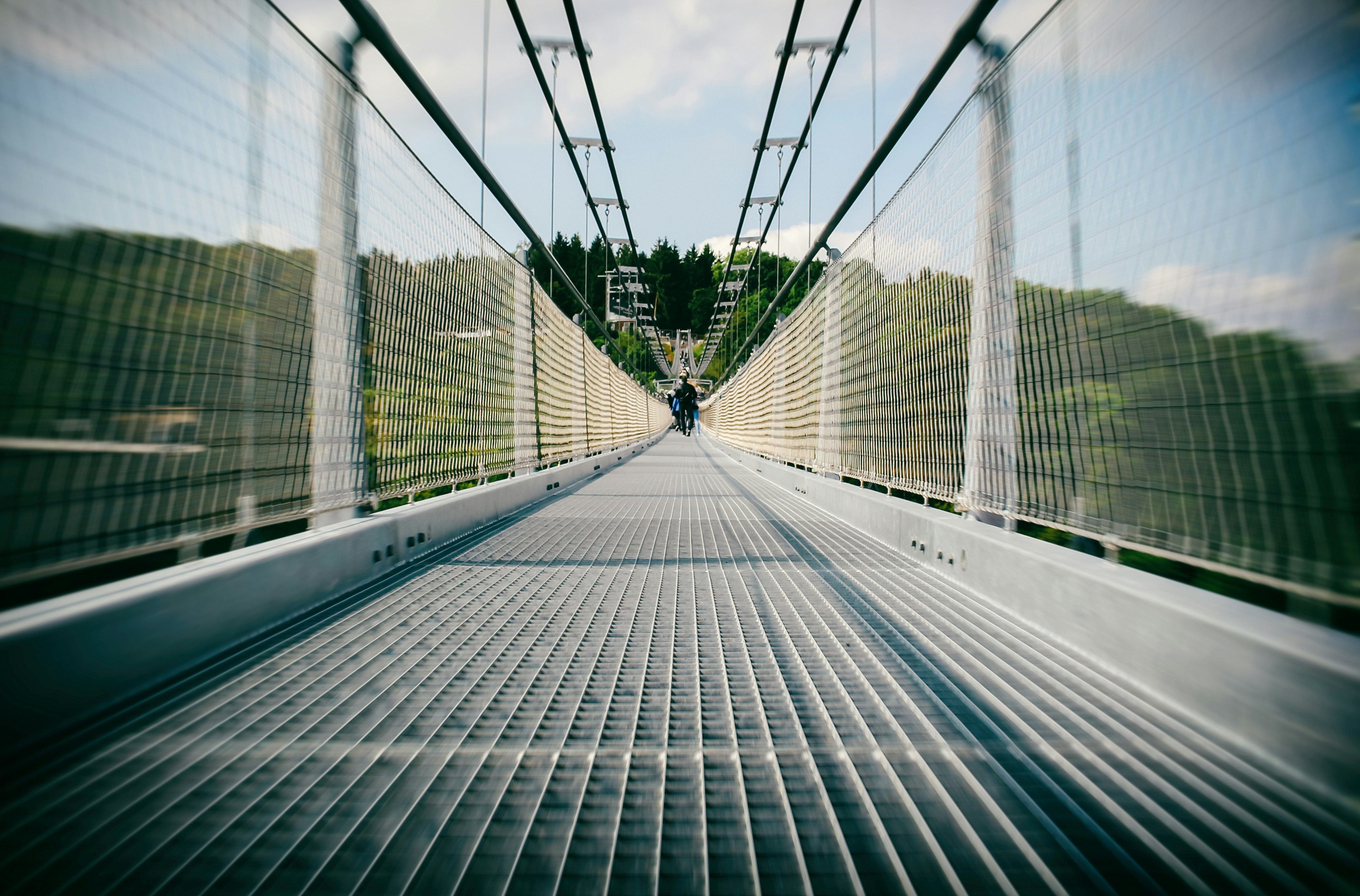 Vanishing Perspective: A Lone Figure on a Steel-Grid Bridge