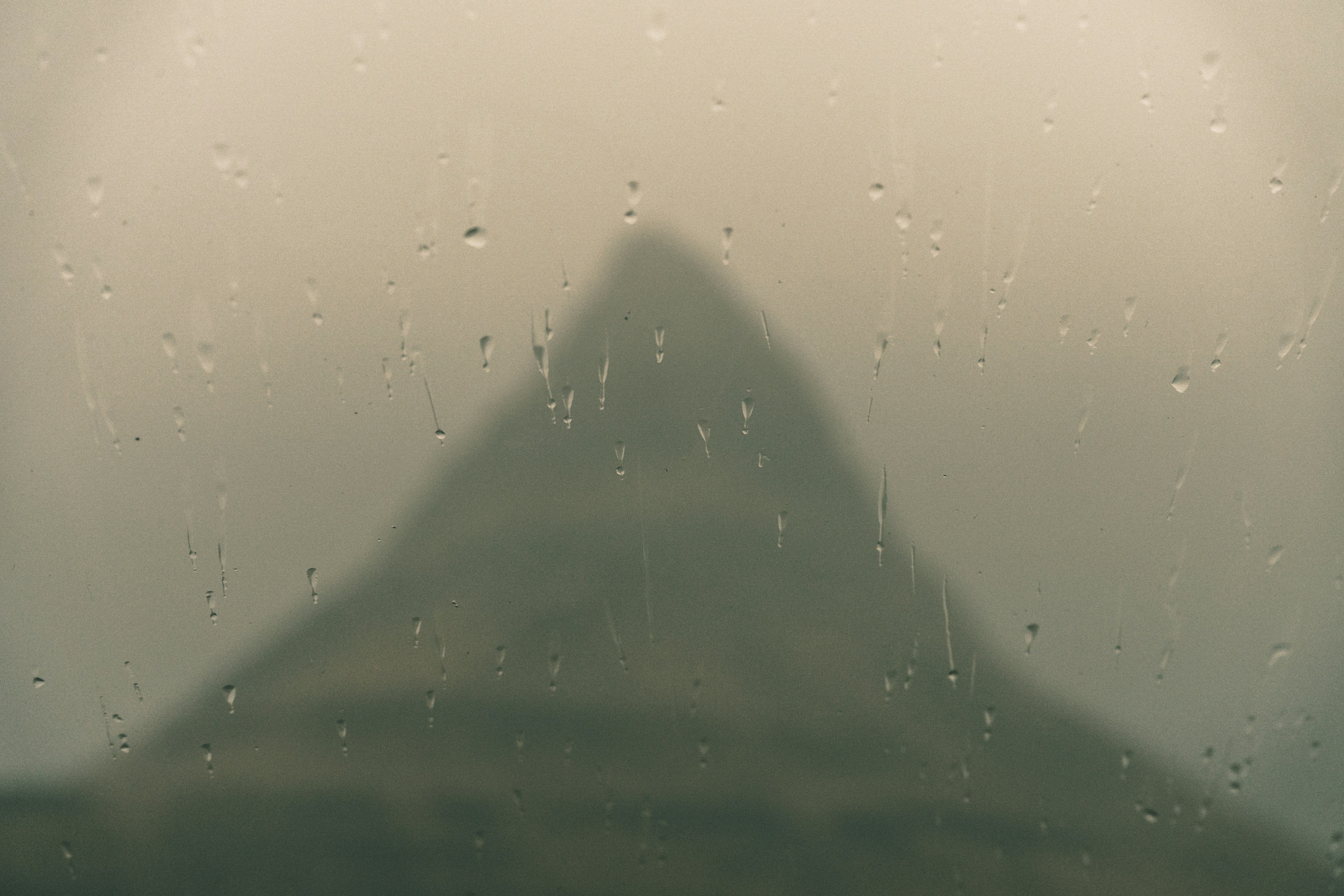 Rain-Streaked Glass Unveils a Silhouetted Summit
