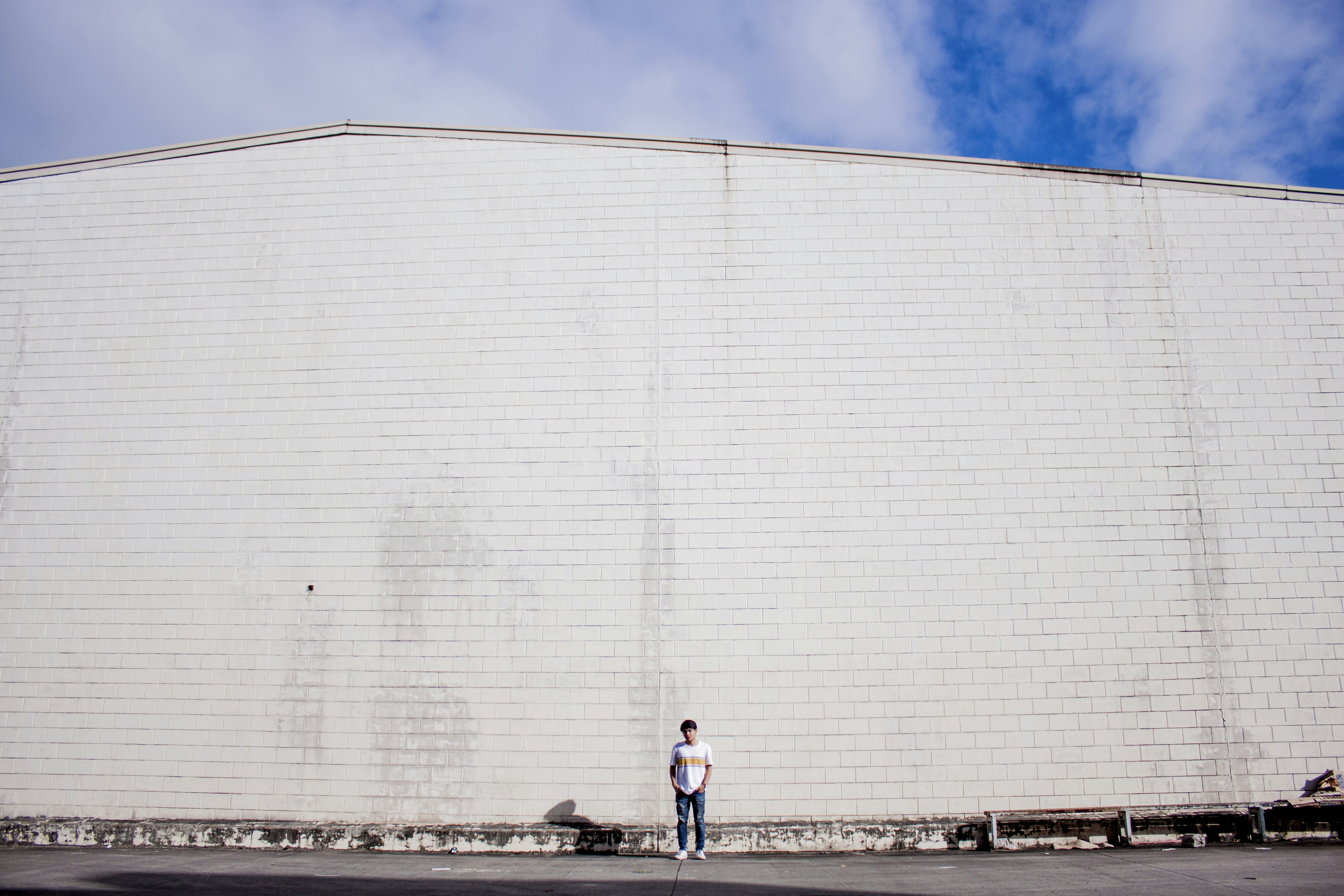 Lone Figure at the Threshold of a Monolithic White Wall