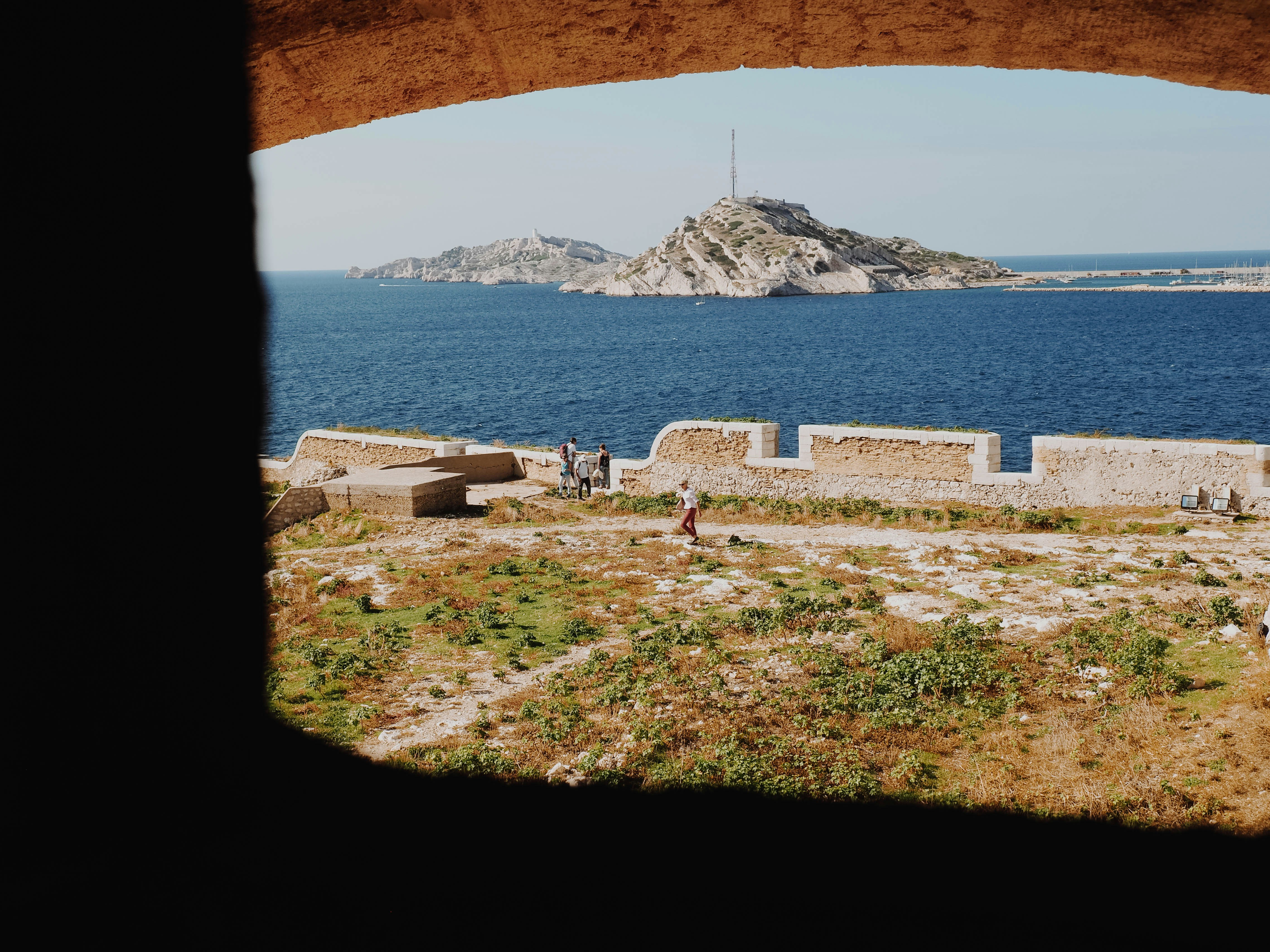 Archway View: A Sea-Islet with a Lone Lighthouse Framed by Daylight