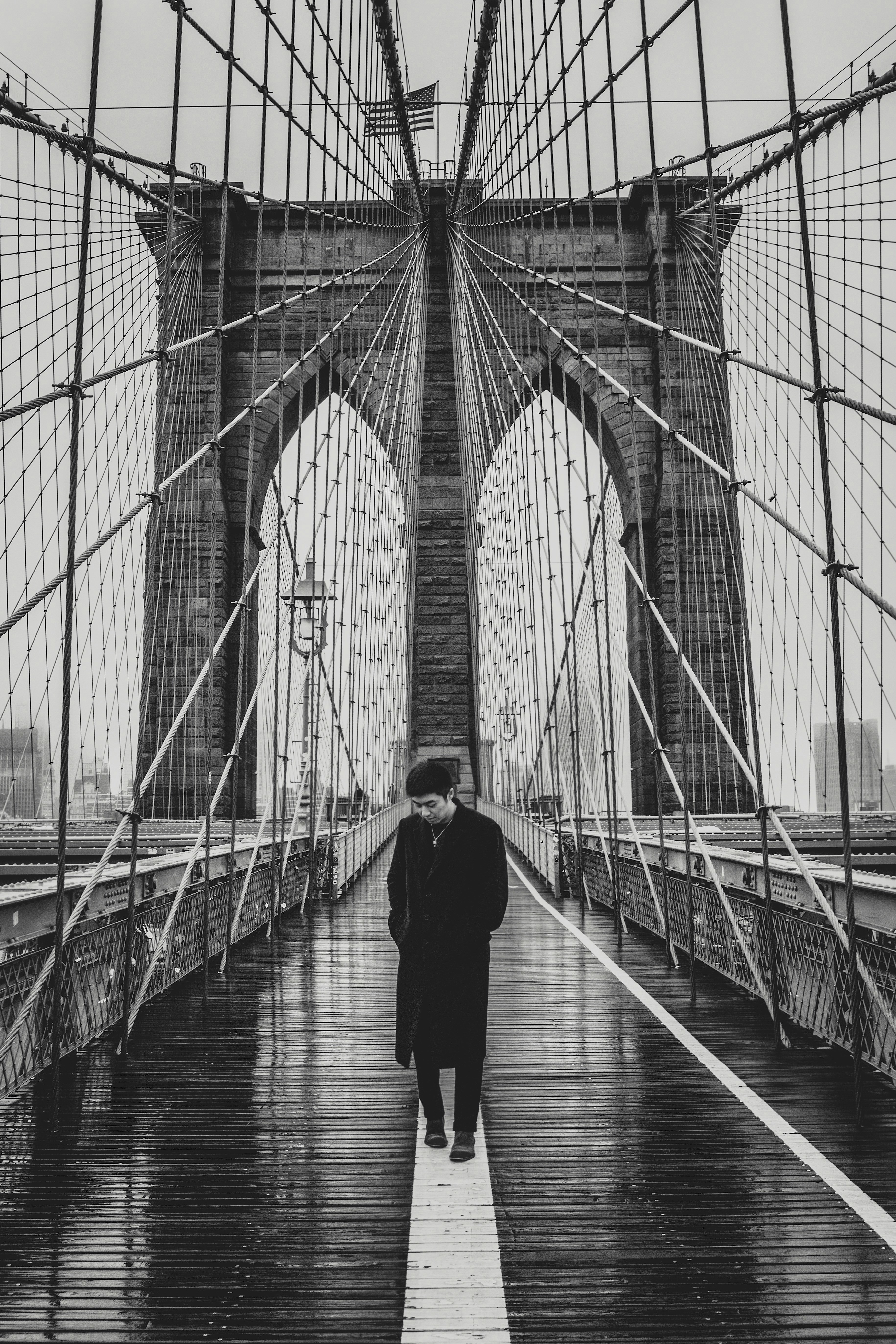 Stride and Suspension: A solitary figure beneath the Brooklyn Bridge
