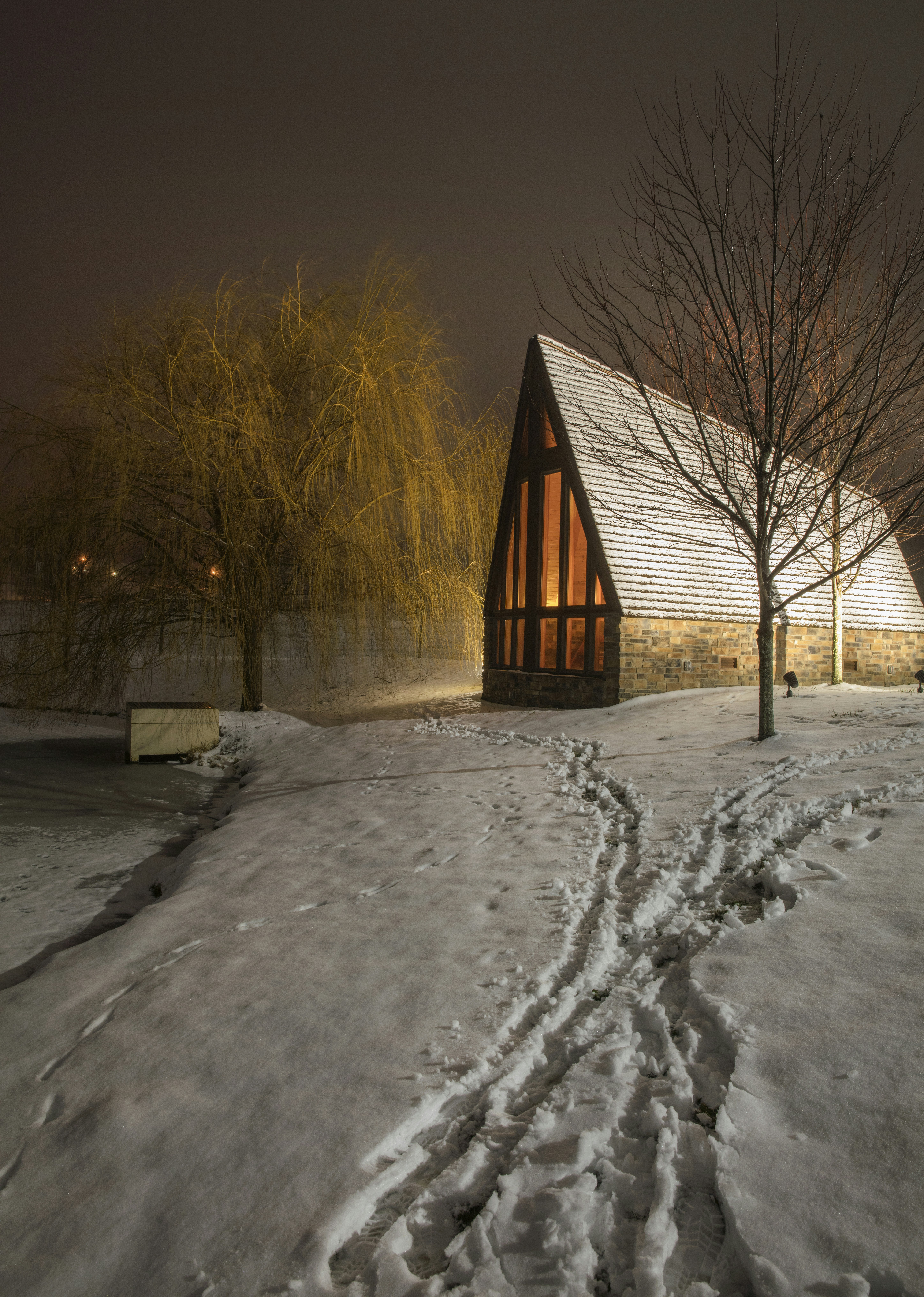 Lantern-lit Timber Chapel Holds Warm Glow Amid Snowy Night