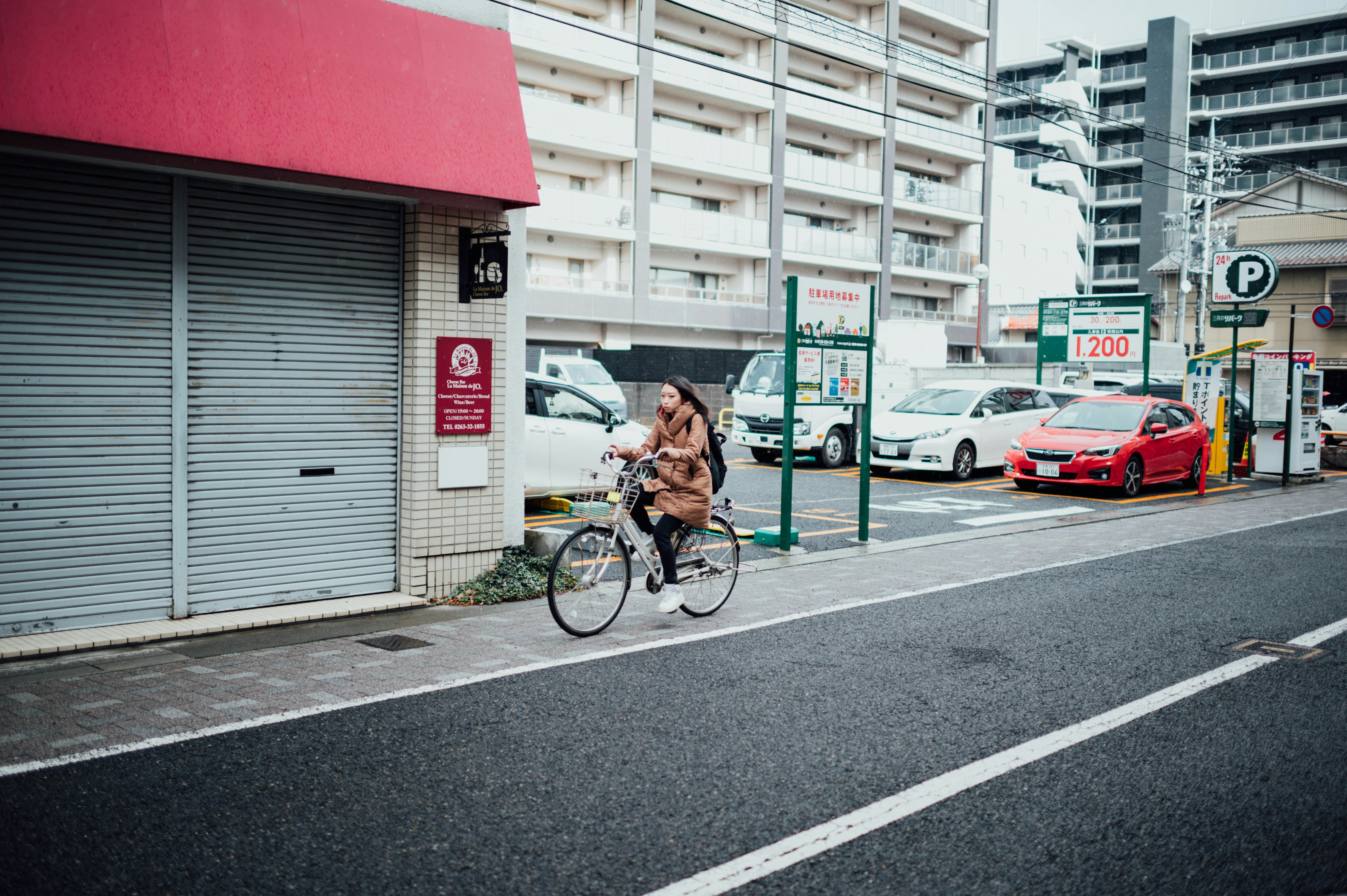 Woman riding city bike riding on asphalt road during day time photo ...